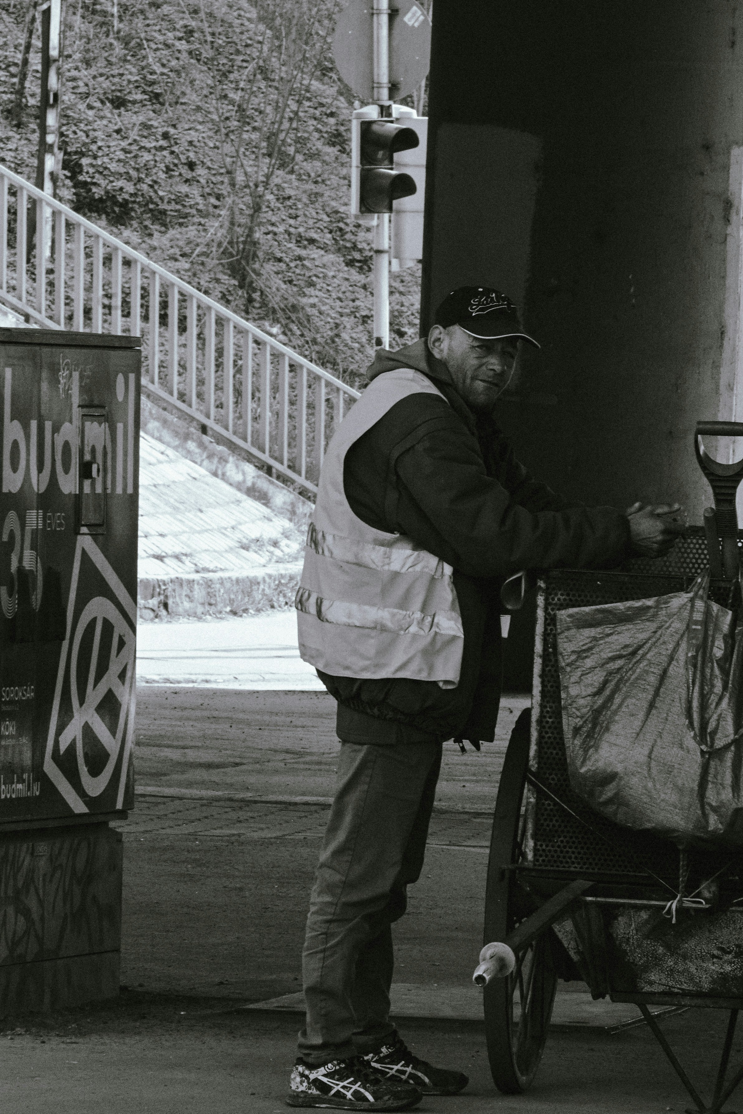 Street Vendor in Grayscale: A Moment Beneath the Overpass