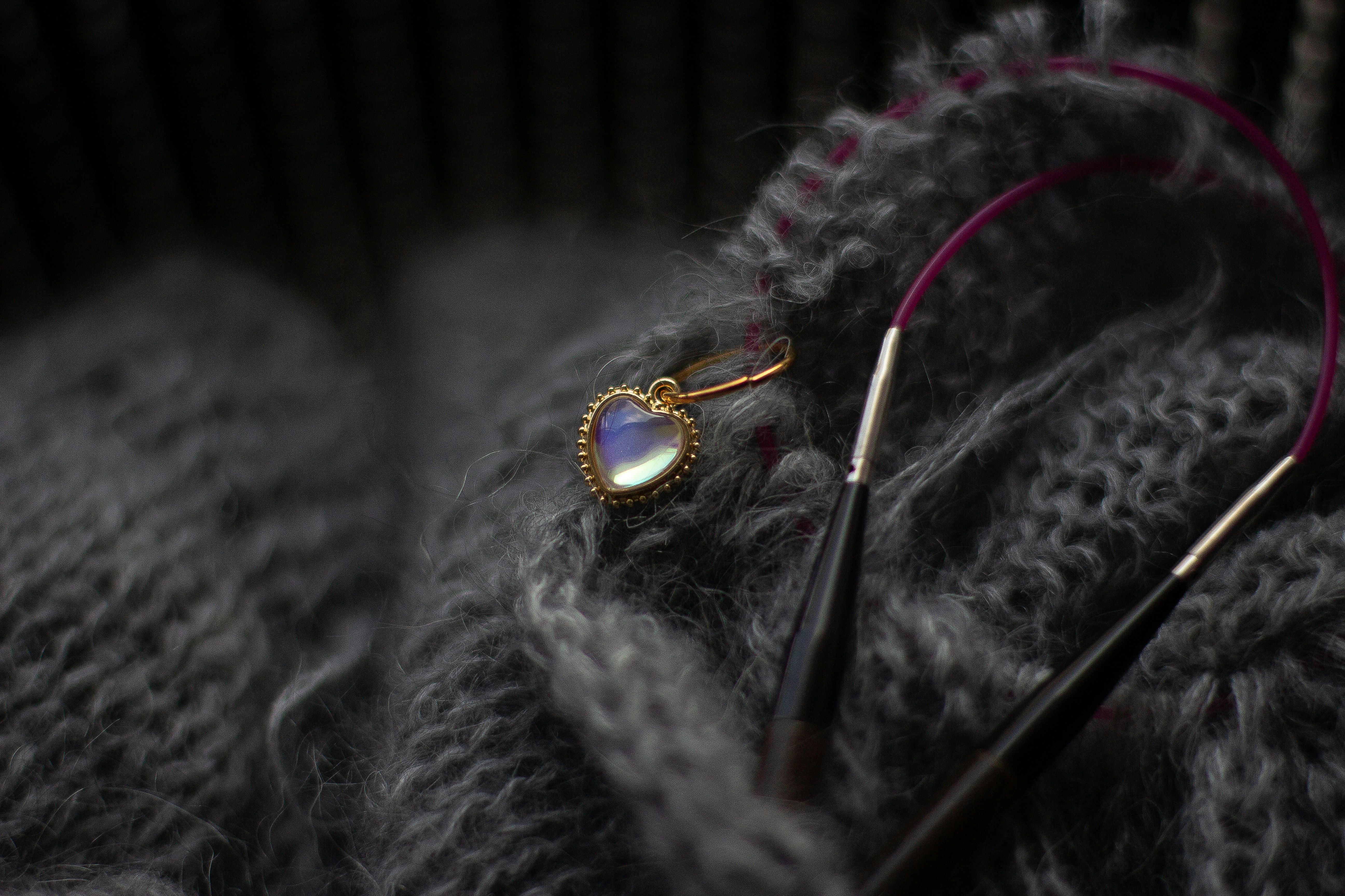 Heart of Craft: A Tiny Pendant Among Knitted Threads