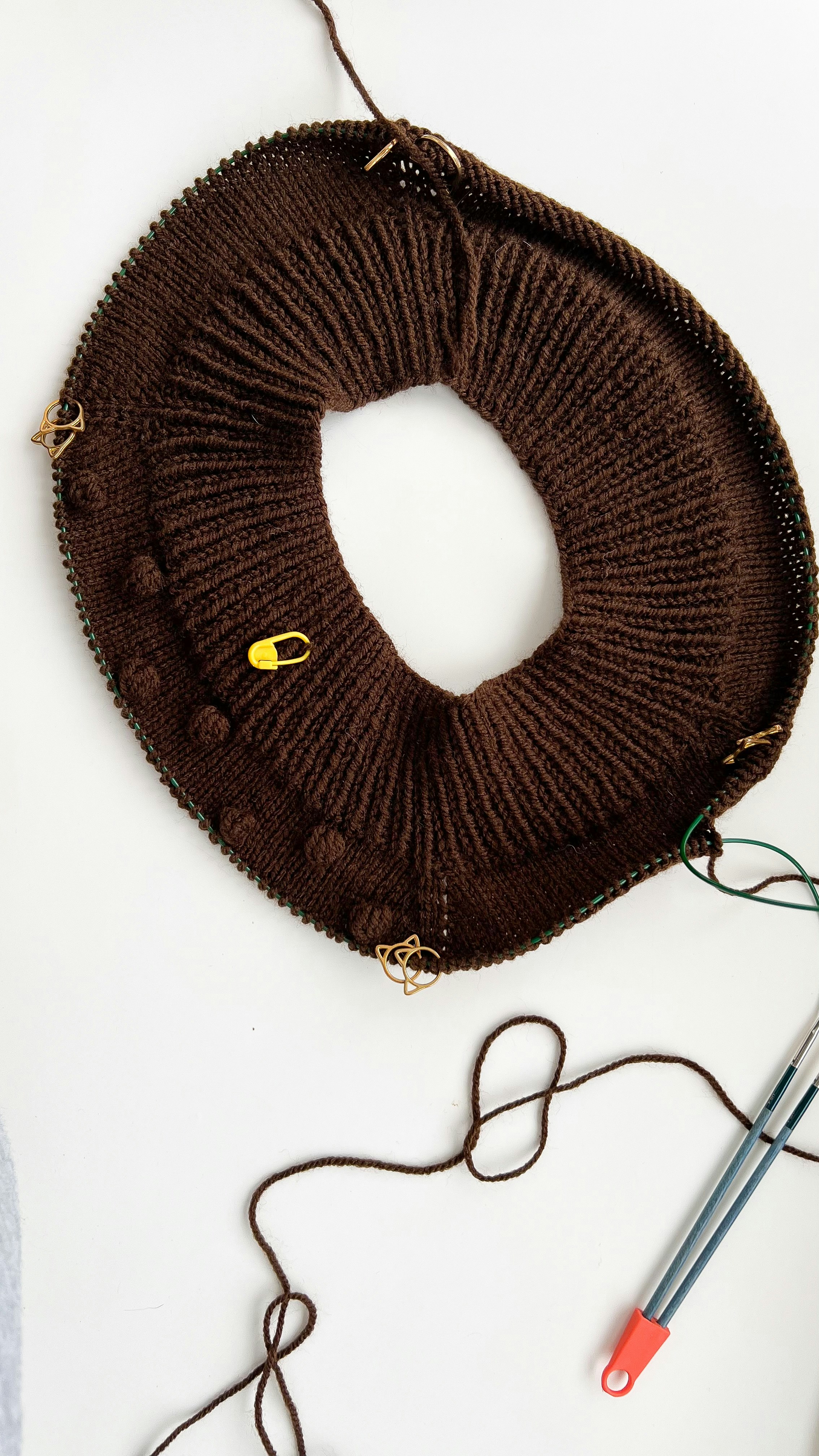 Brown circular knitting loom with yarn and tools