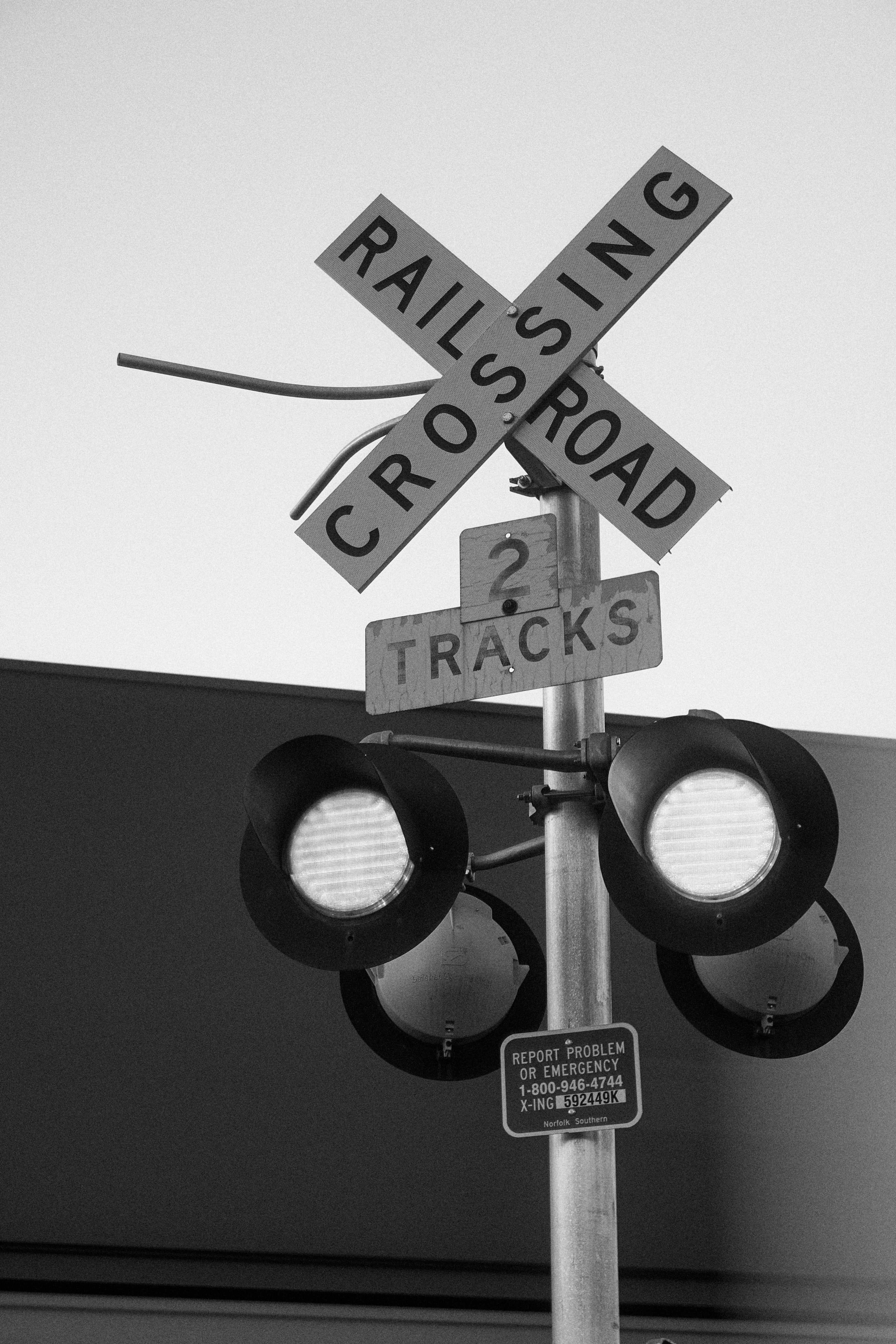 Crossing Signals: A Black-and-White Moment at the Rail Crossing