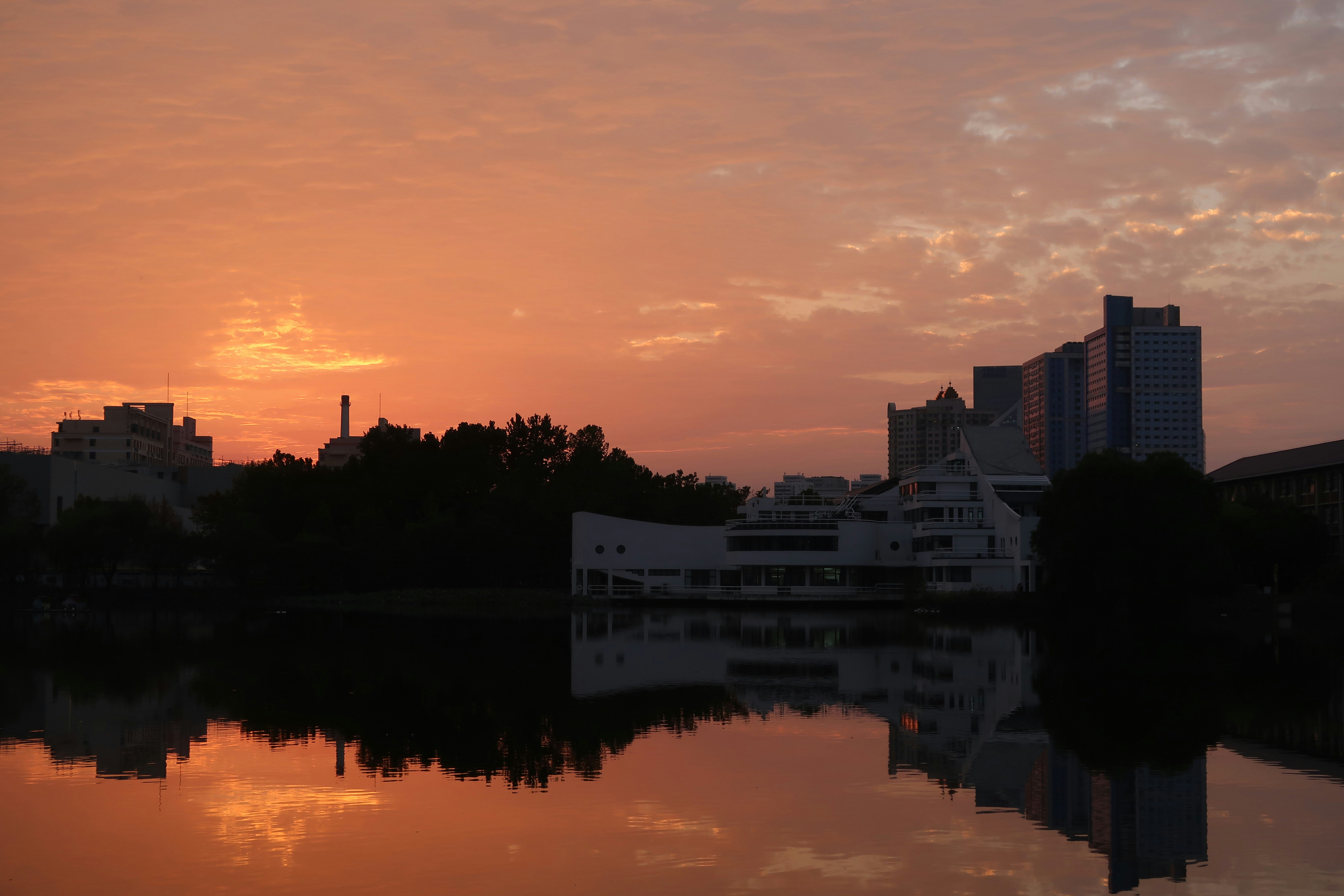 Silhouette at Sunset Over a Mirror-Lake Cityscape