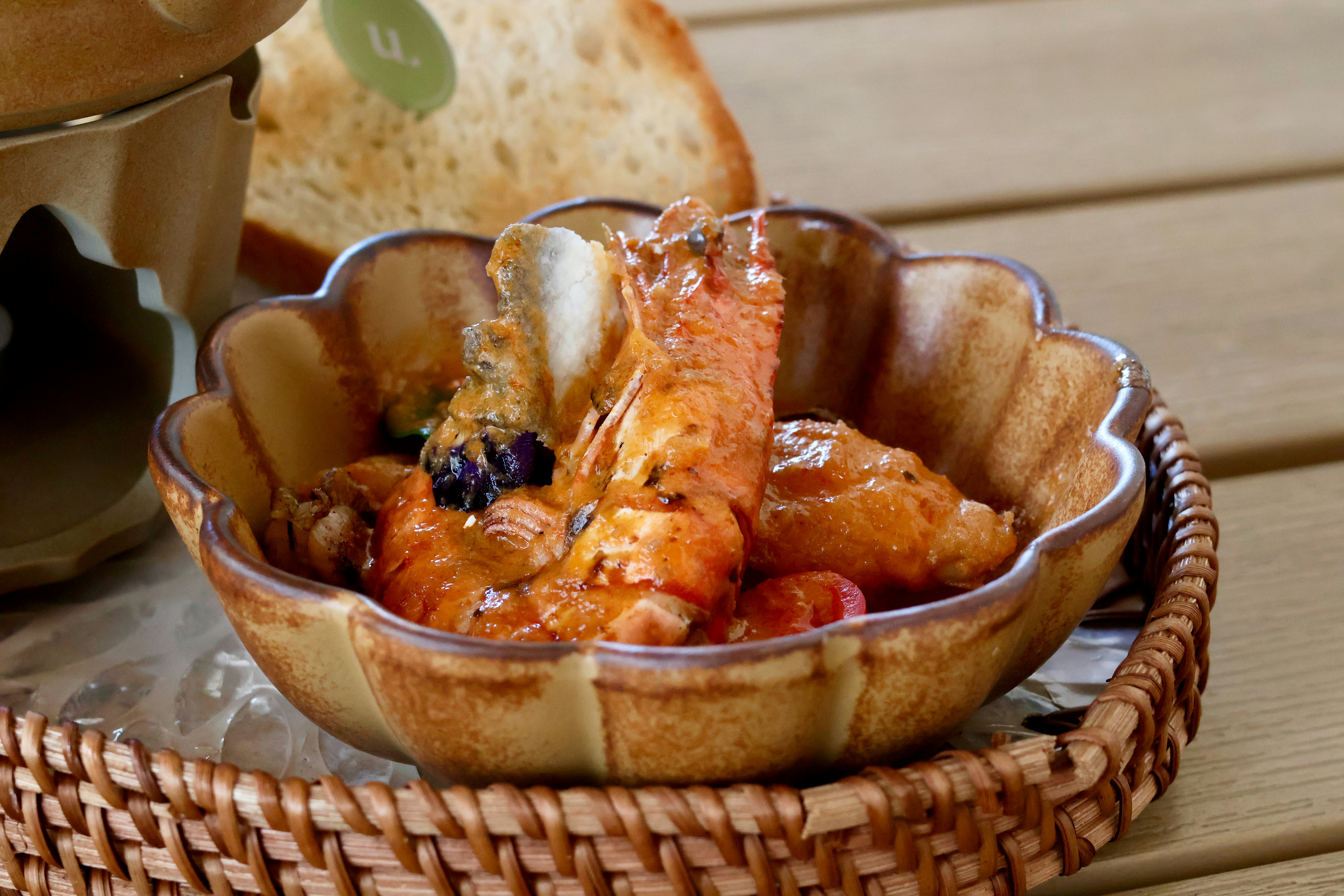 Caramelized shrimp and pastry bowl on a woven tray