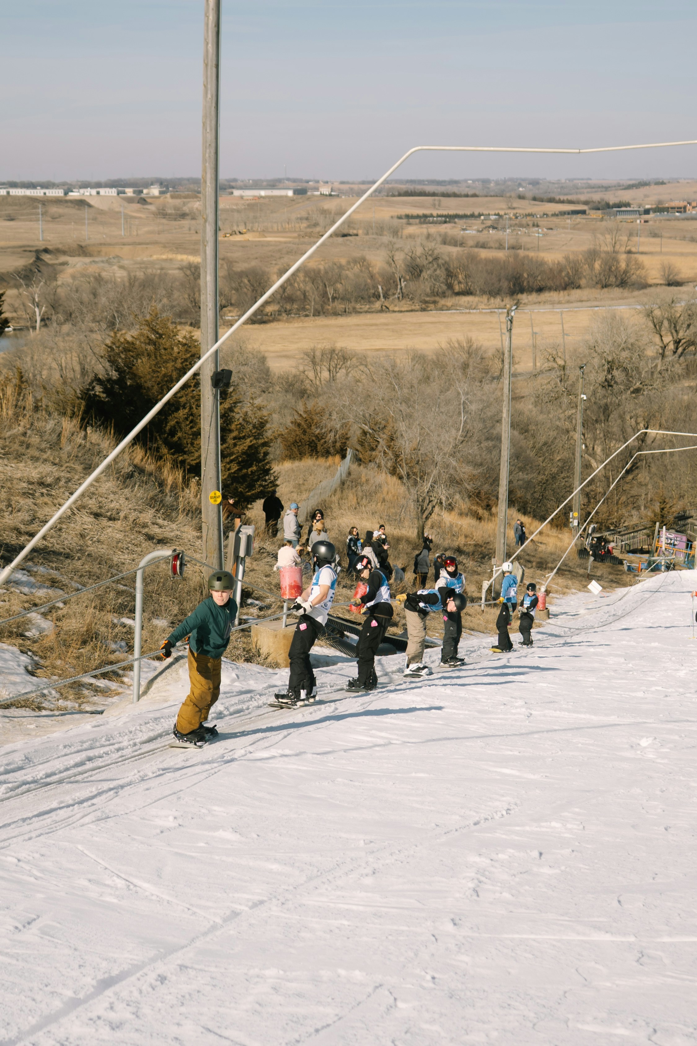 Skier Lineup on Snow-Covered Slopes Framing a Winter Plain