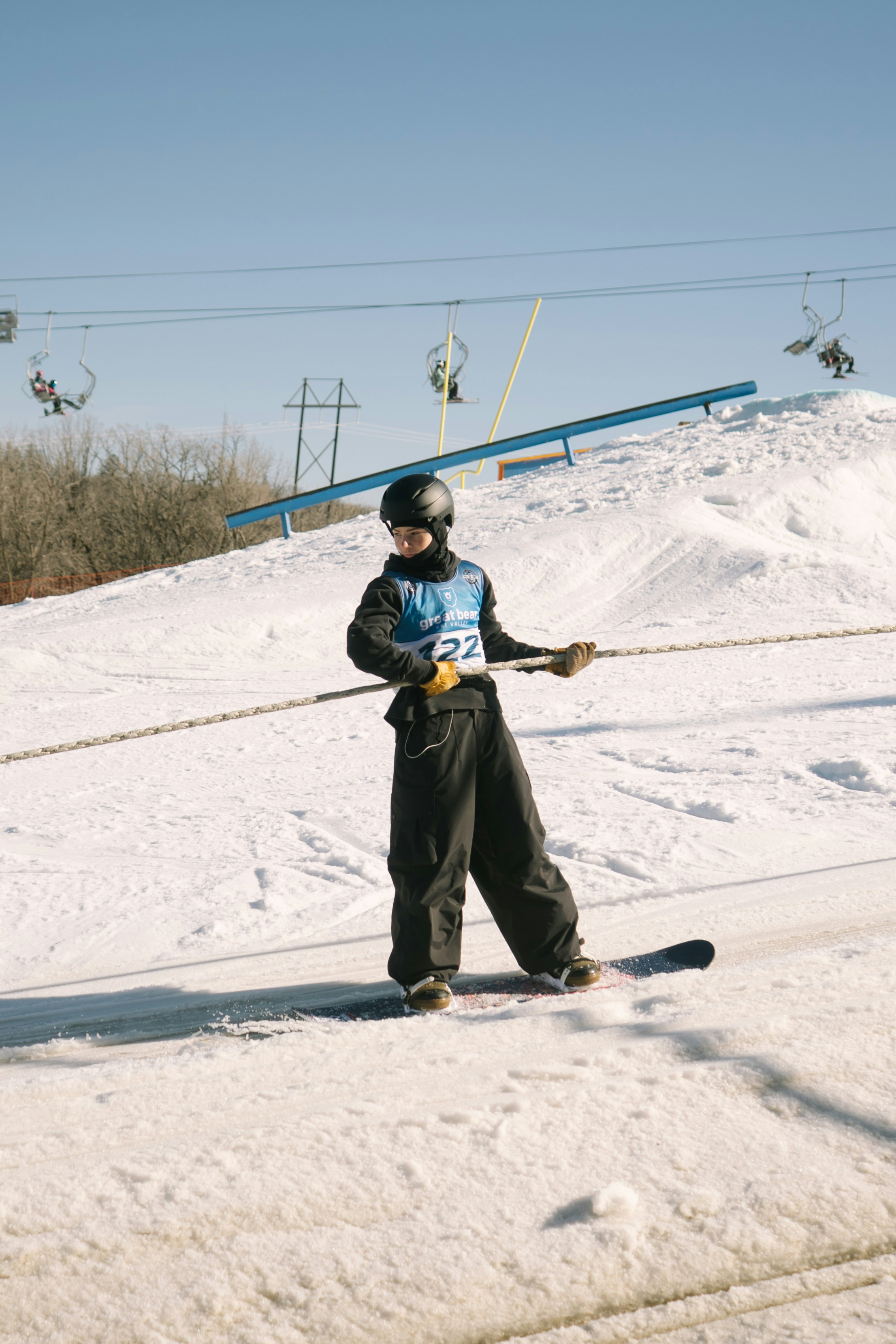 Snowboarder in mid-run: confident stance under a blue rail
