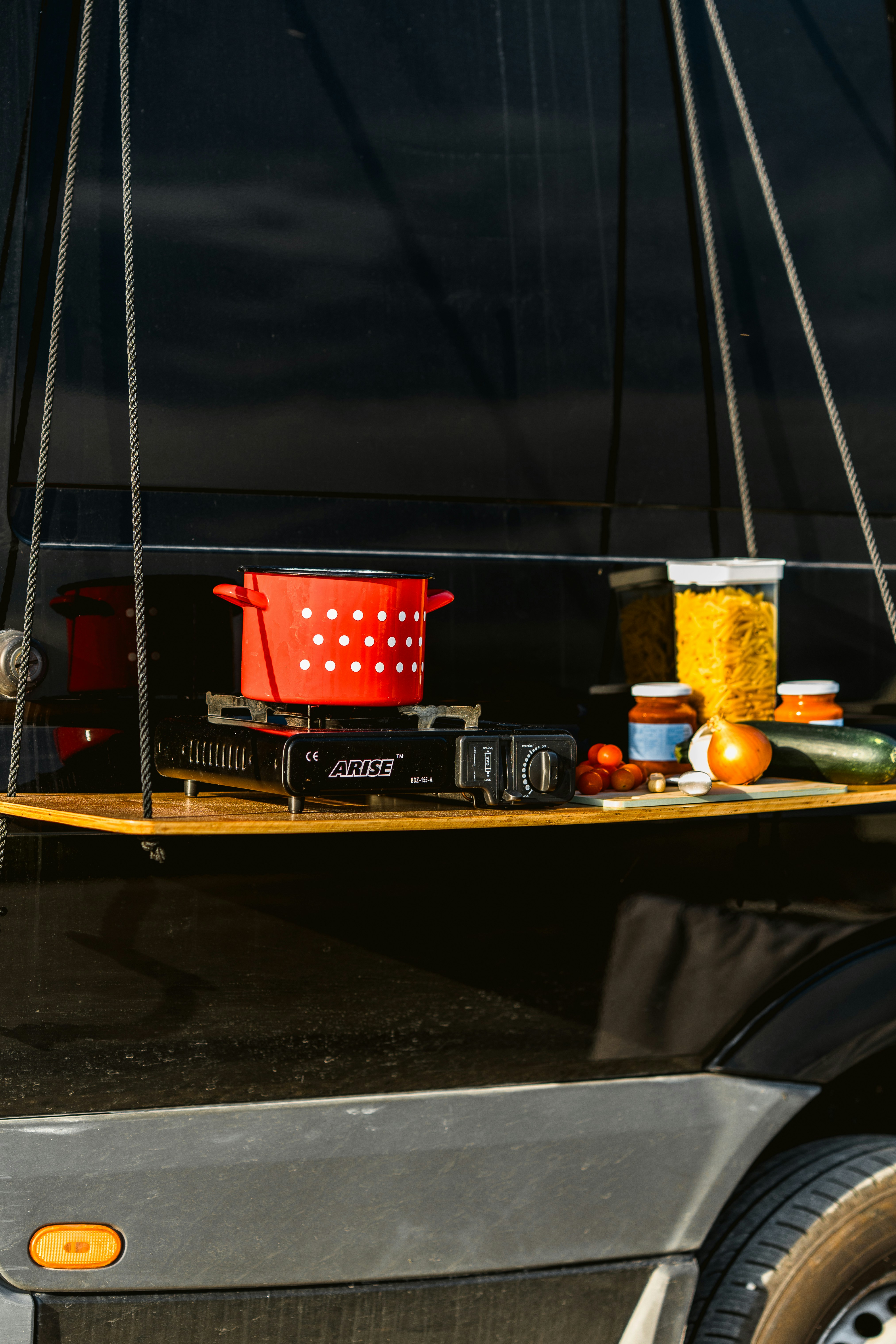 A Kitchen on a Truck Bed: Red Pot on a Portable Stove