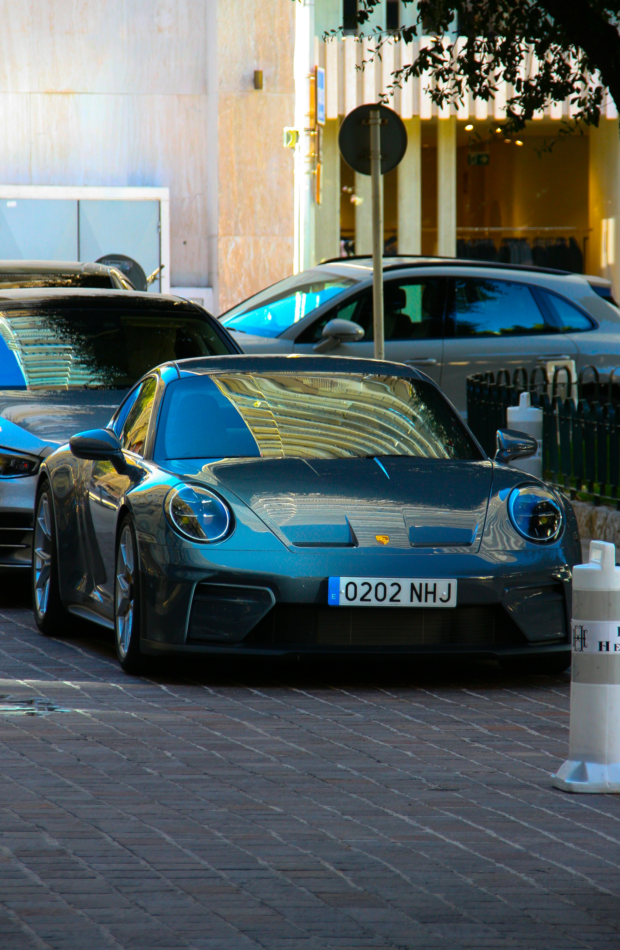 Midday Mirage: The Blue Porsche Anchored in Urban Dappled Light