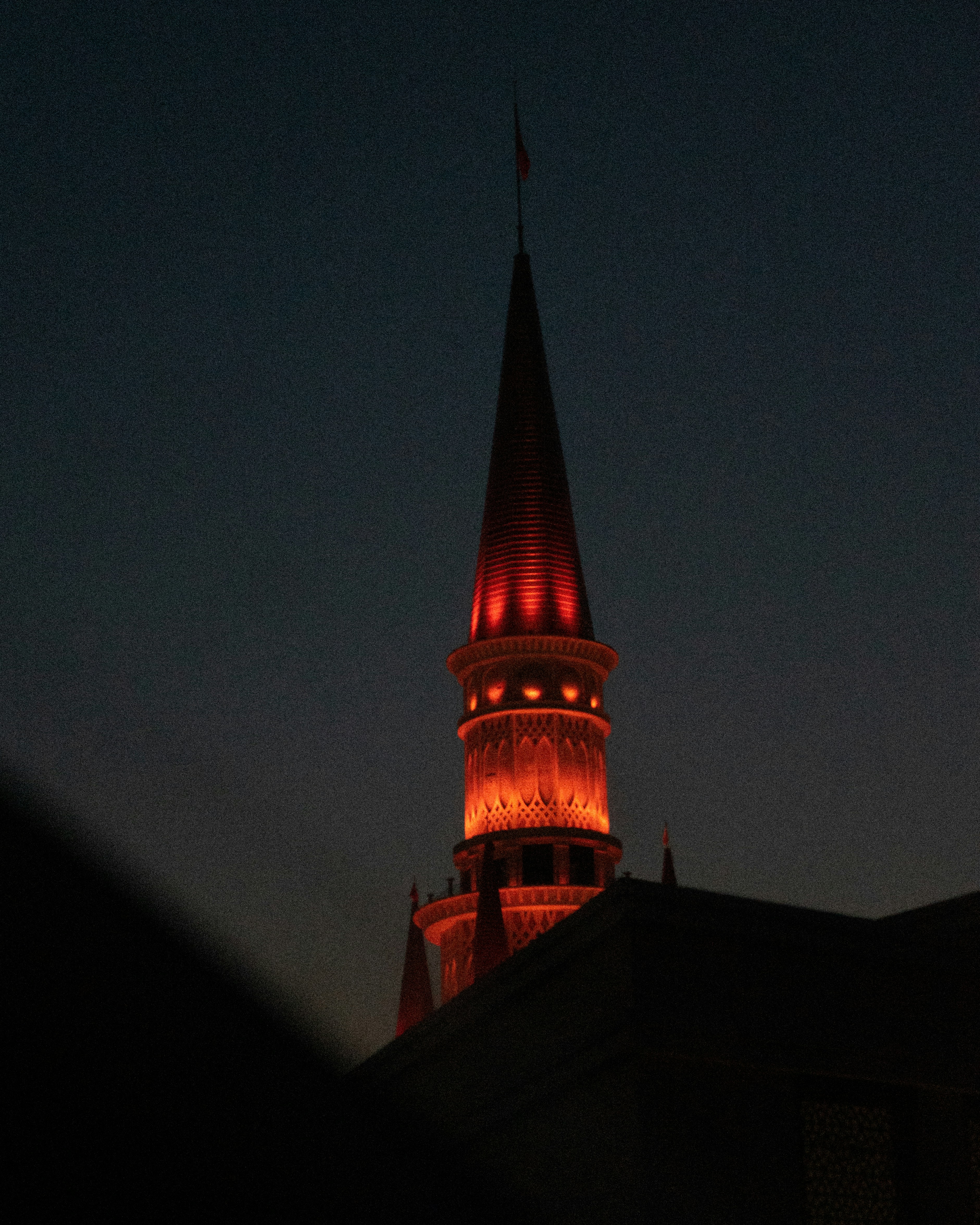 Red Tower at Dusk: A City Spire Illuminated in Quiet Night