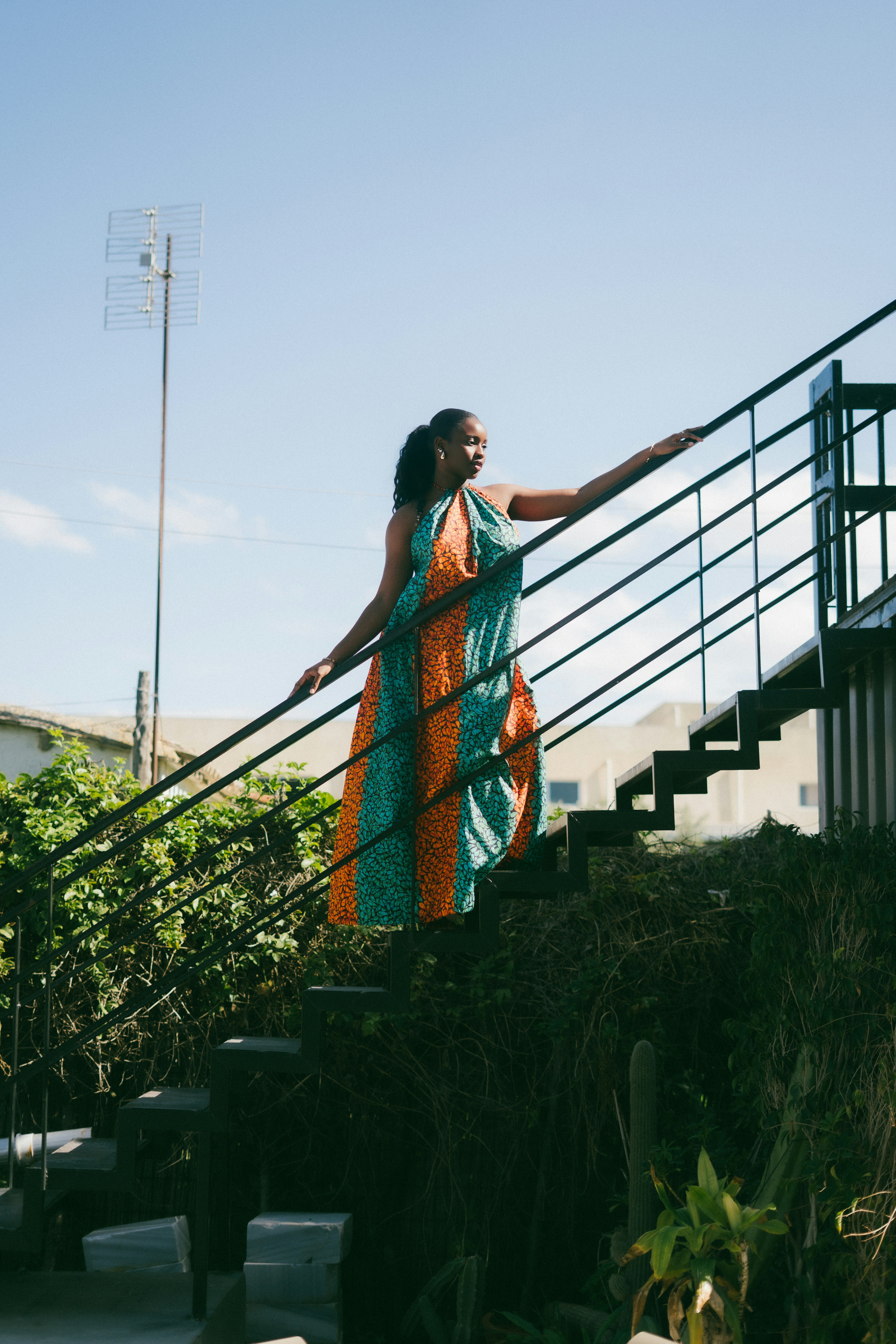 Stride on Sunlit Stairs: A Colorful Moment on the Railing