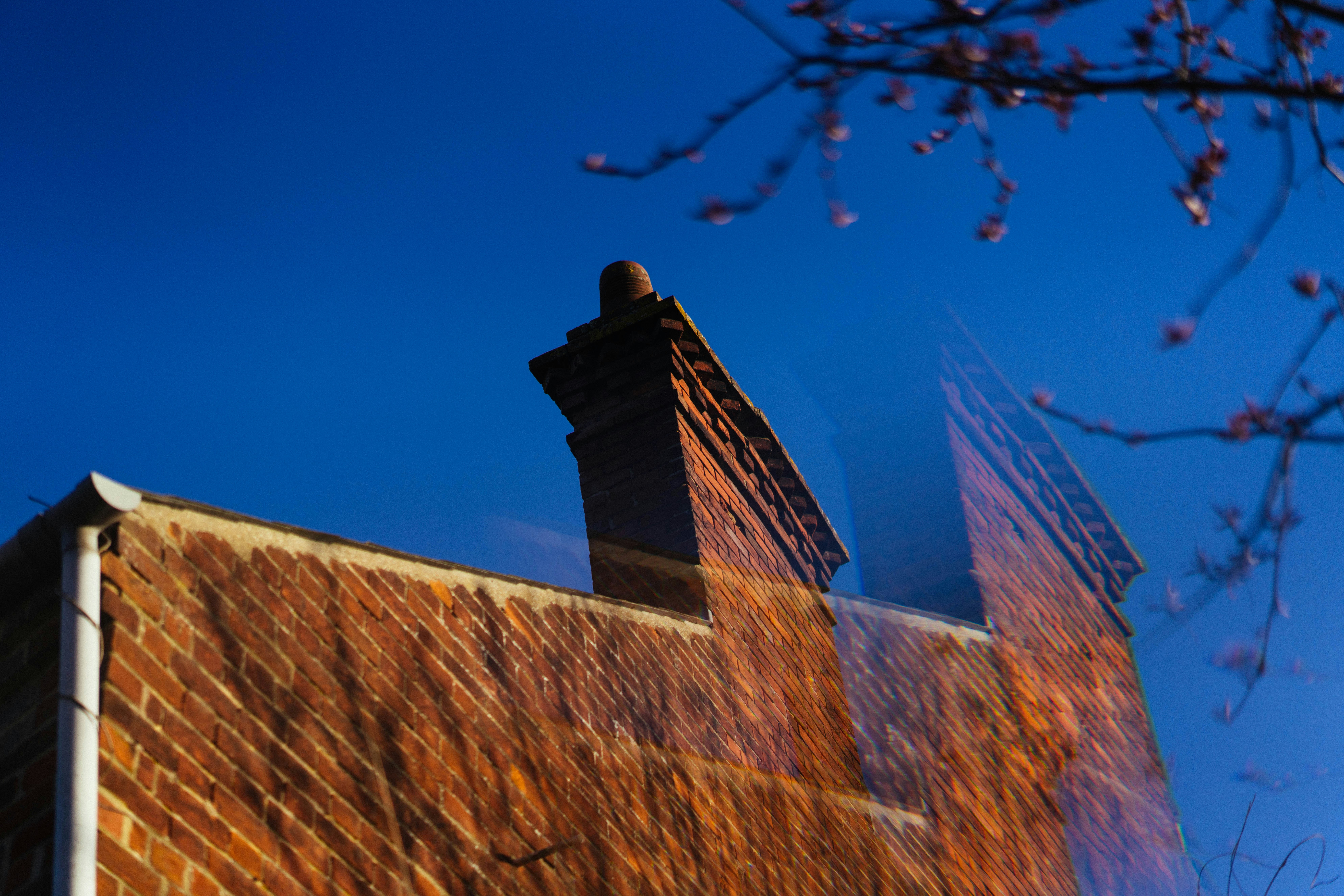 Brick Chimneys Against a Bright Blue Sky with Light Fringing