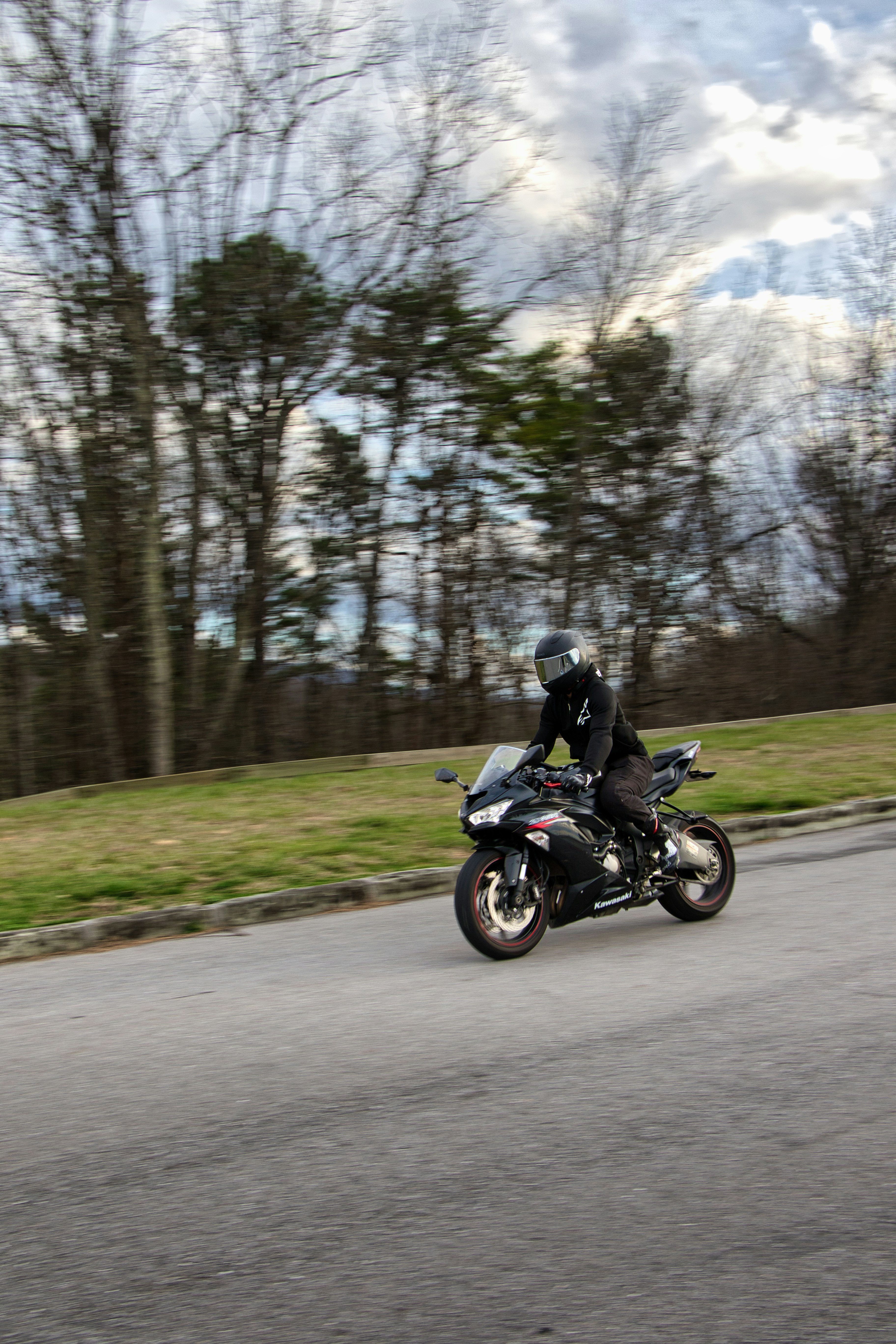 Street-leaning sprint: rider in motion on a black sportbike