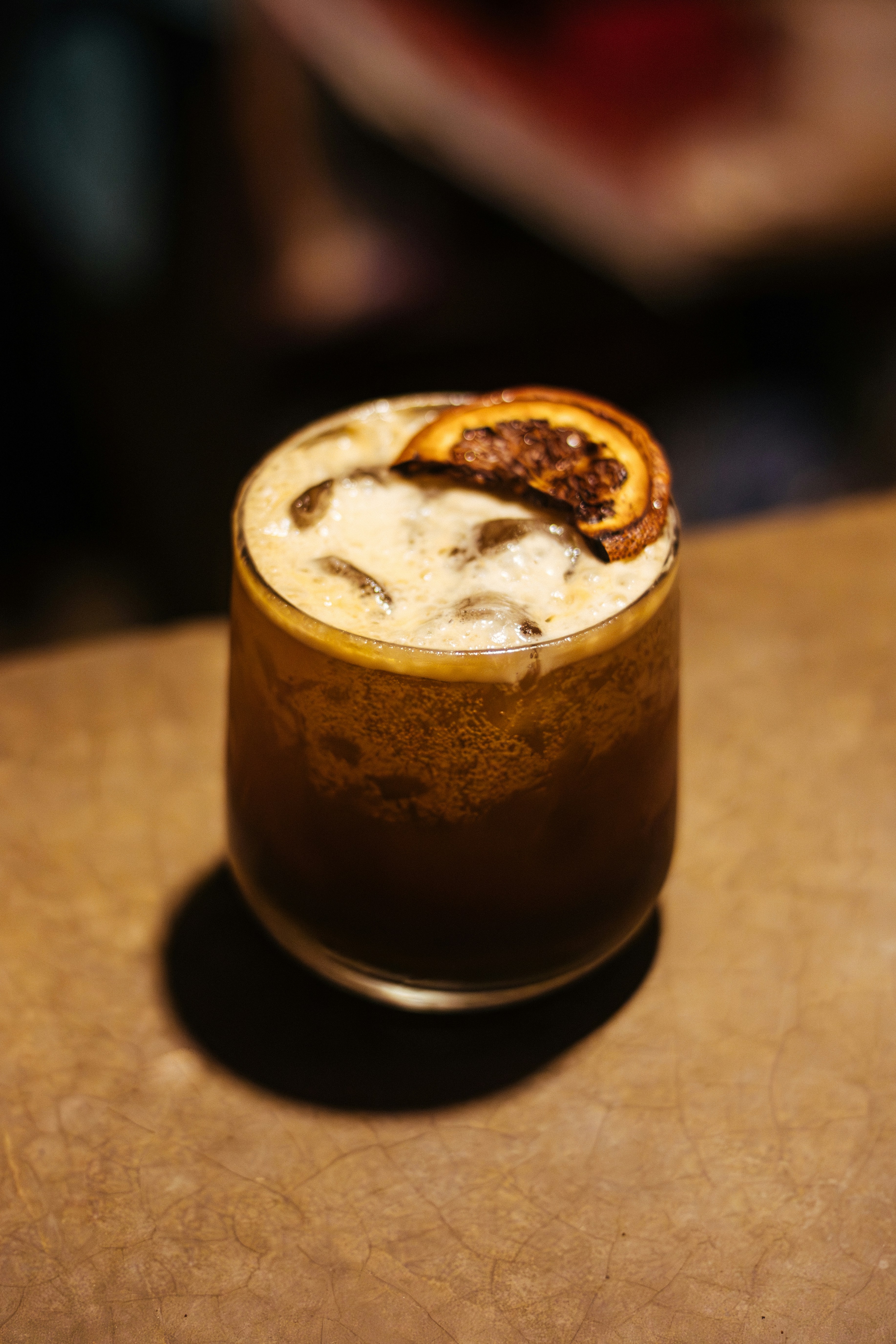 Salted Caramel Foam: A Glassy Coffee Scene with Toasted Orange Garnish