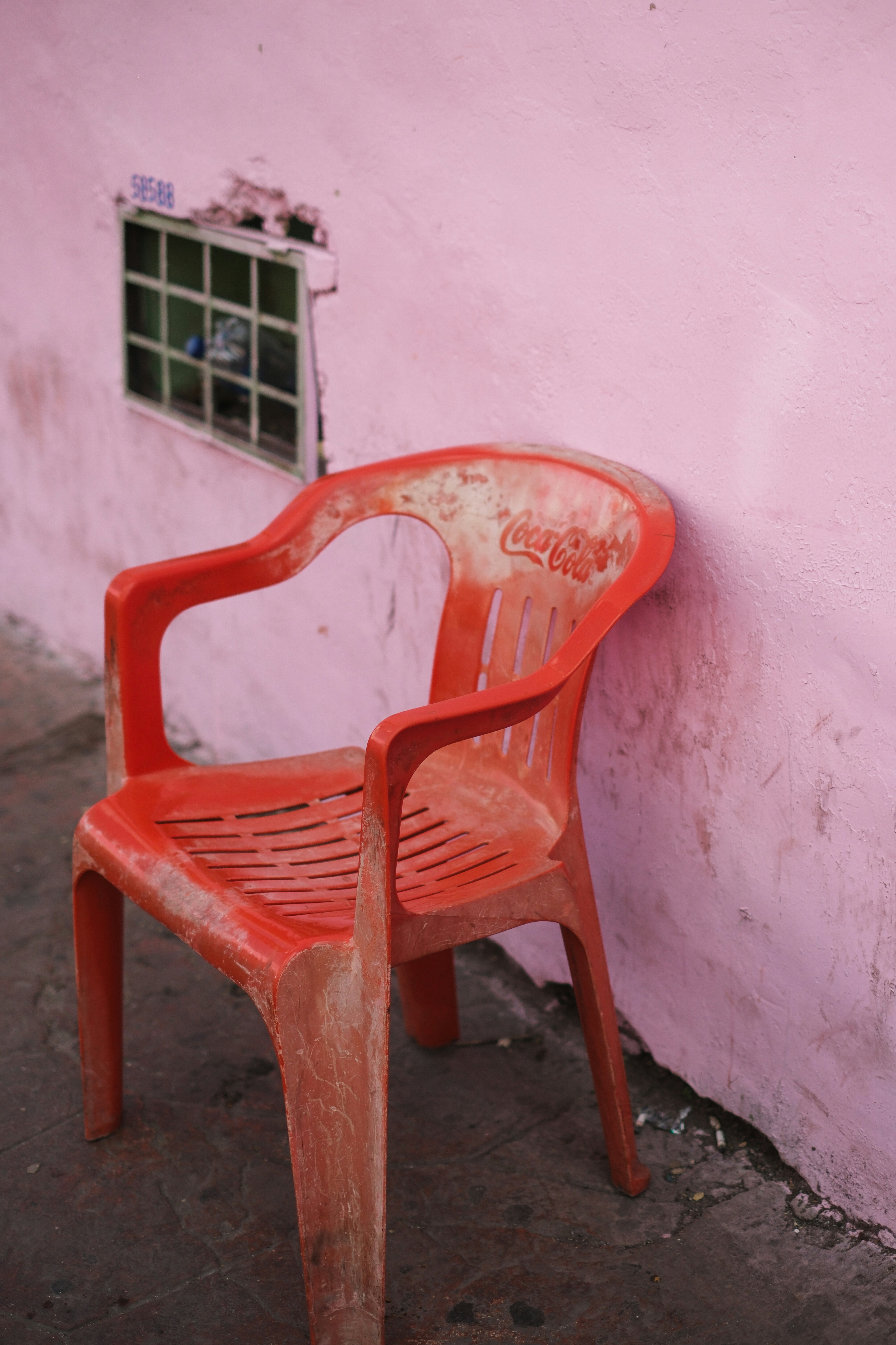 Red Plastic Chair by a Pink Wall