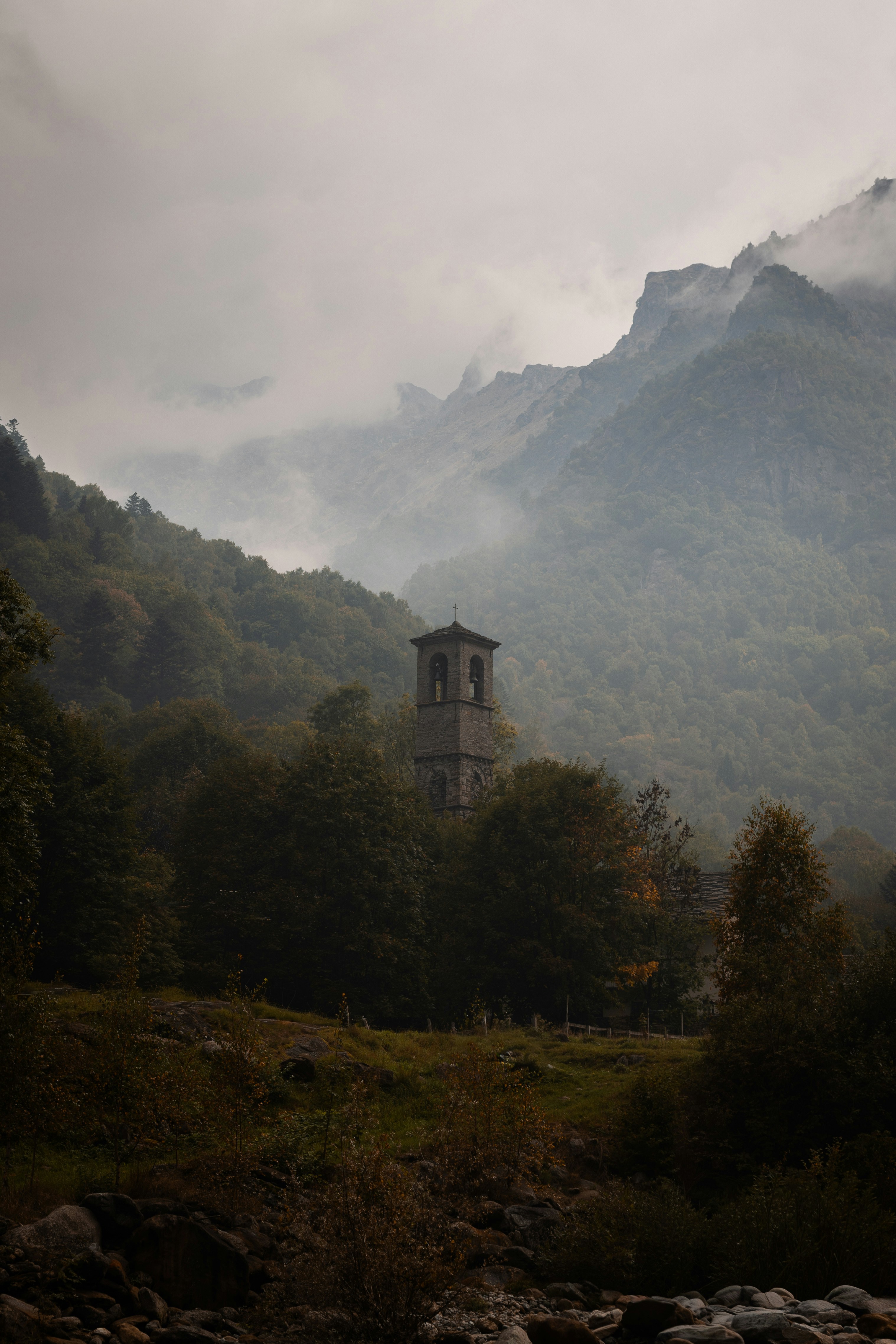 Stone Bell Tower Emerging Through the Misty Mountaintop Forest