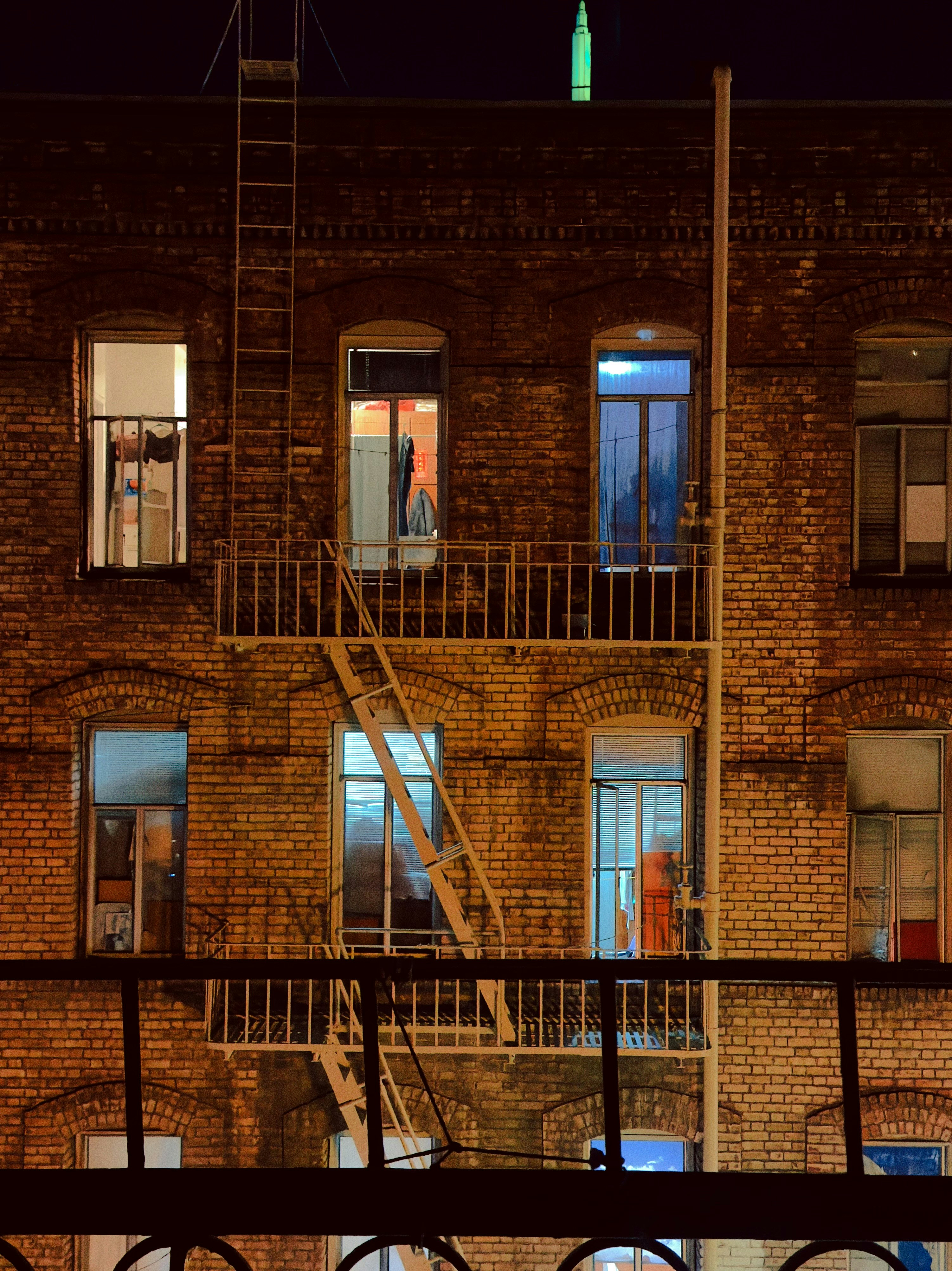 Midnight Fire Escape: Warm Light in a Brick Backdrop