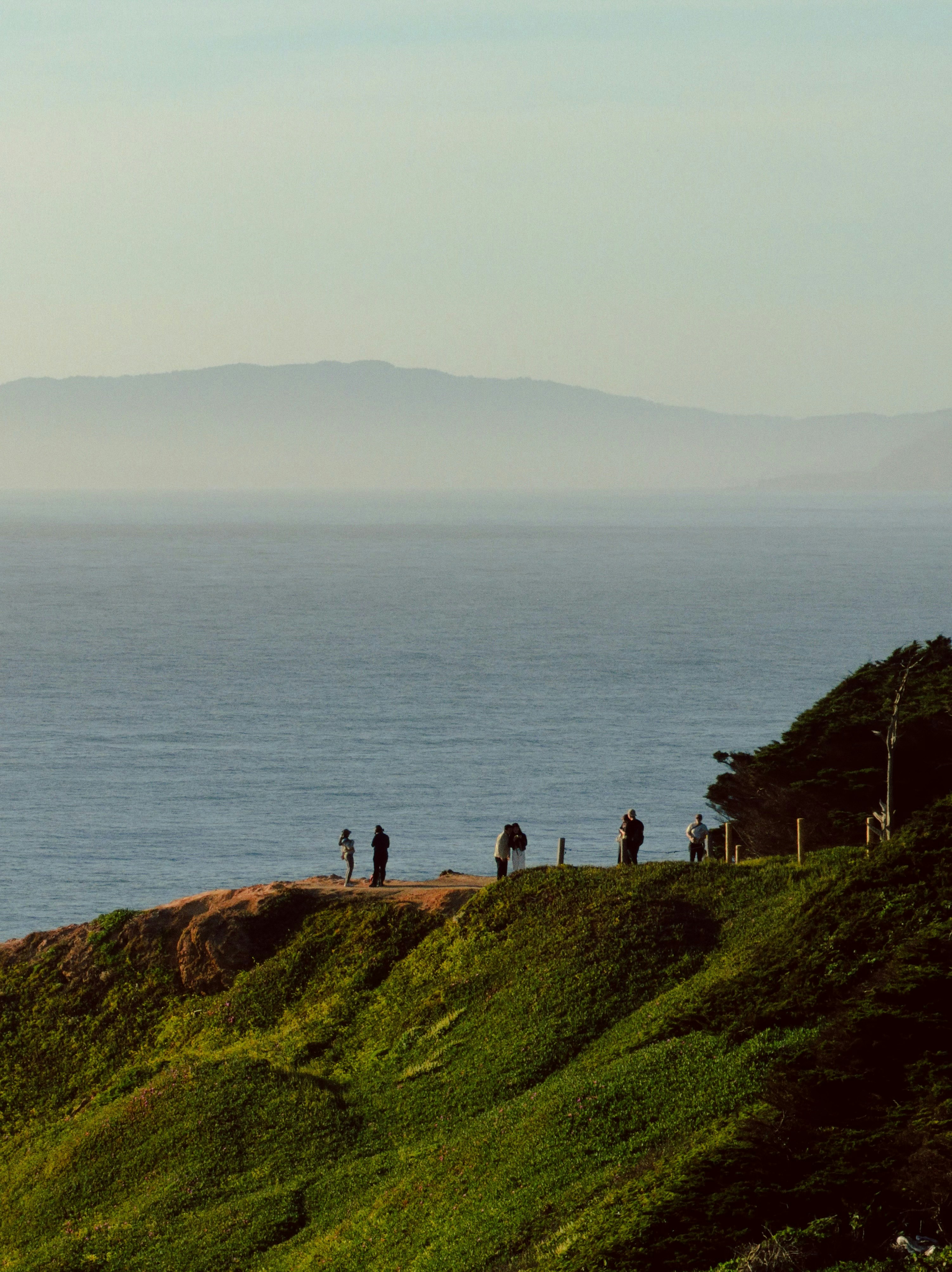 Clifftop silhouettes against a tranquil sea