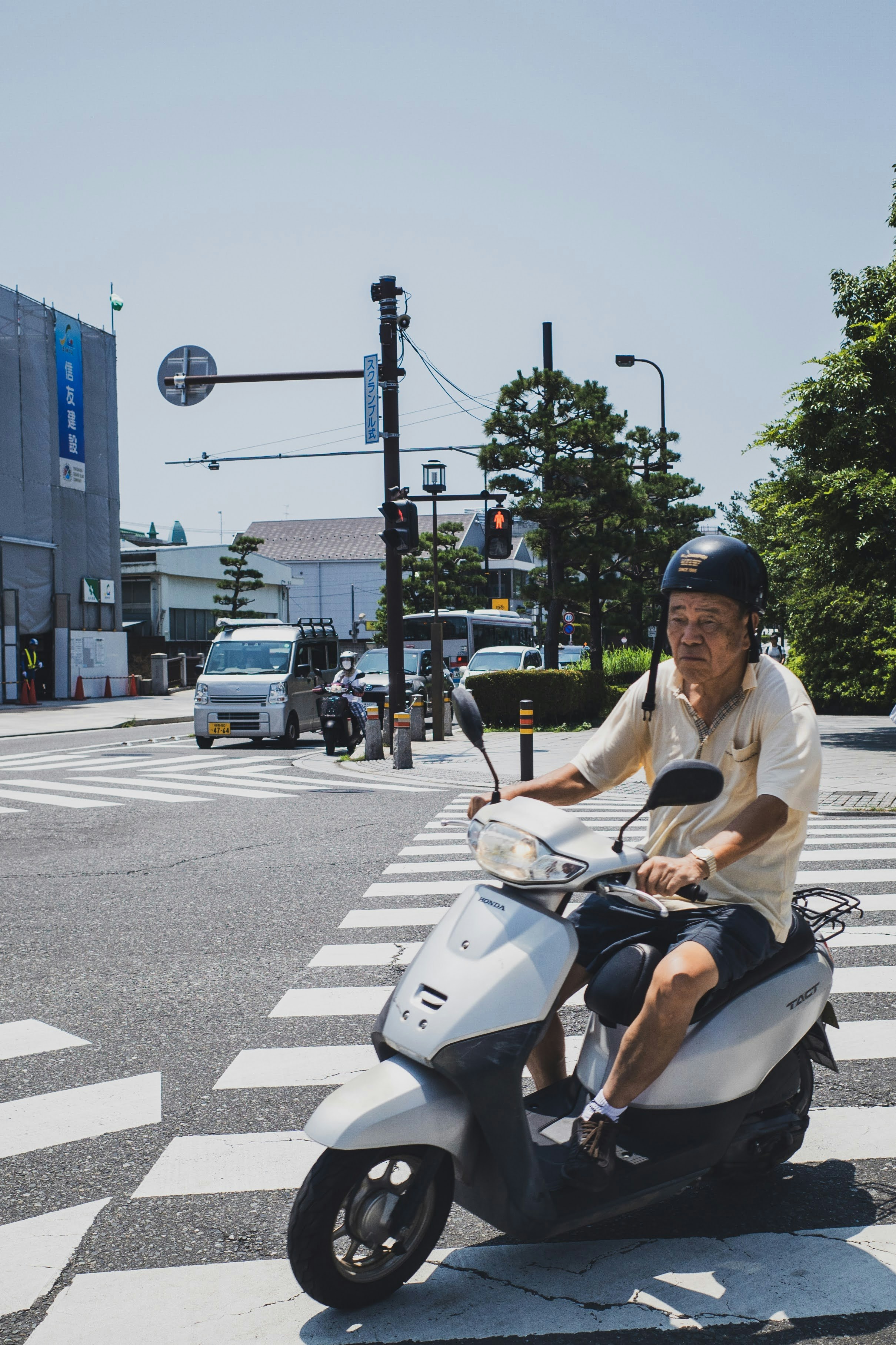 Urban Crossing: Elderly Rider Navigates a Sunlit Intersection