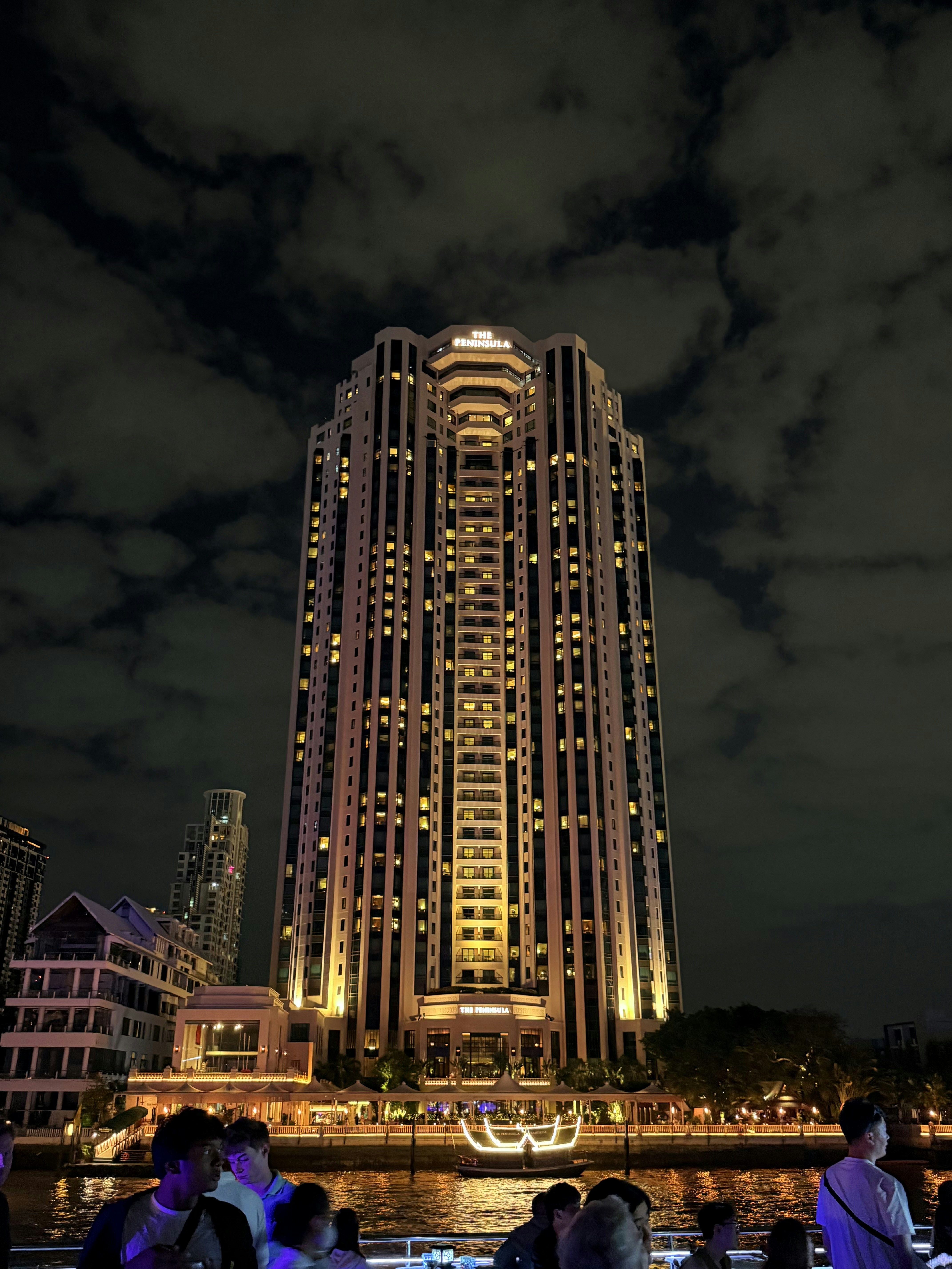Skyline at Night: Lantern-lit Tower Rising from the Riverfront