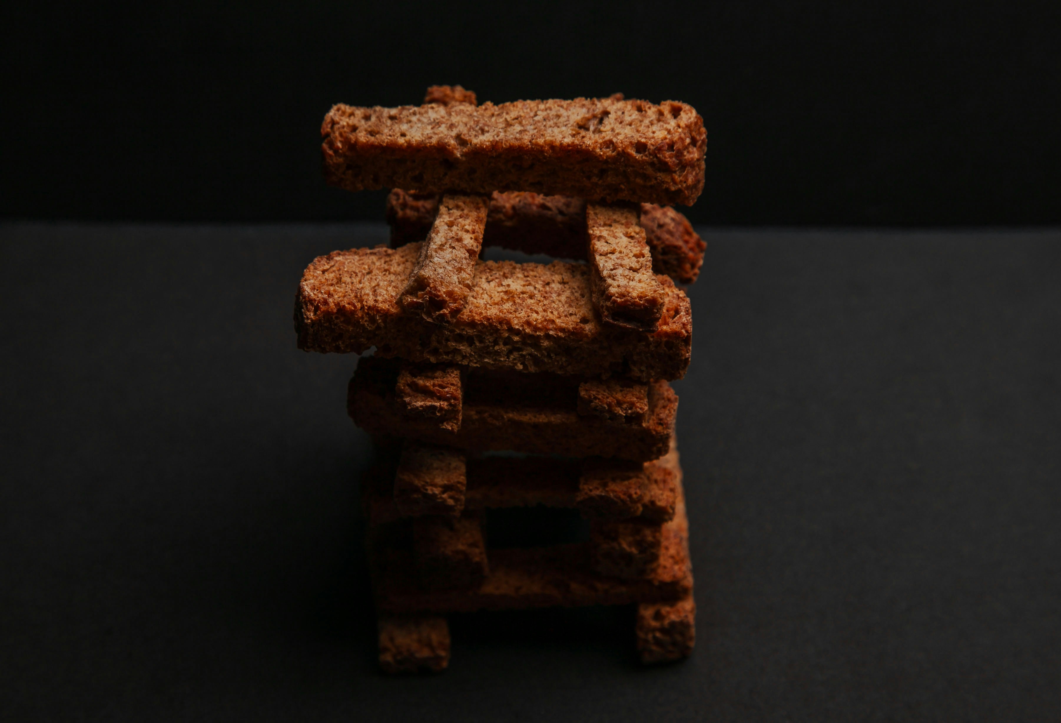 Stacked Irony: A Quiet Tower of Cinnamon Crumbs on a Dark Stage