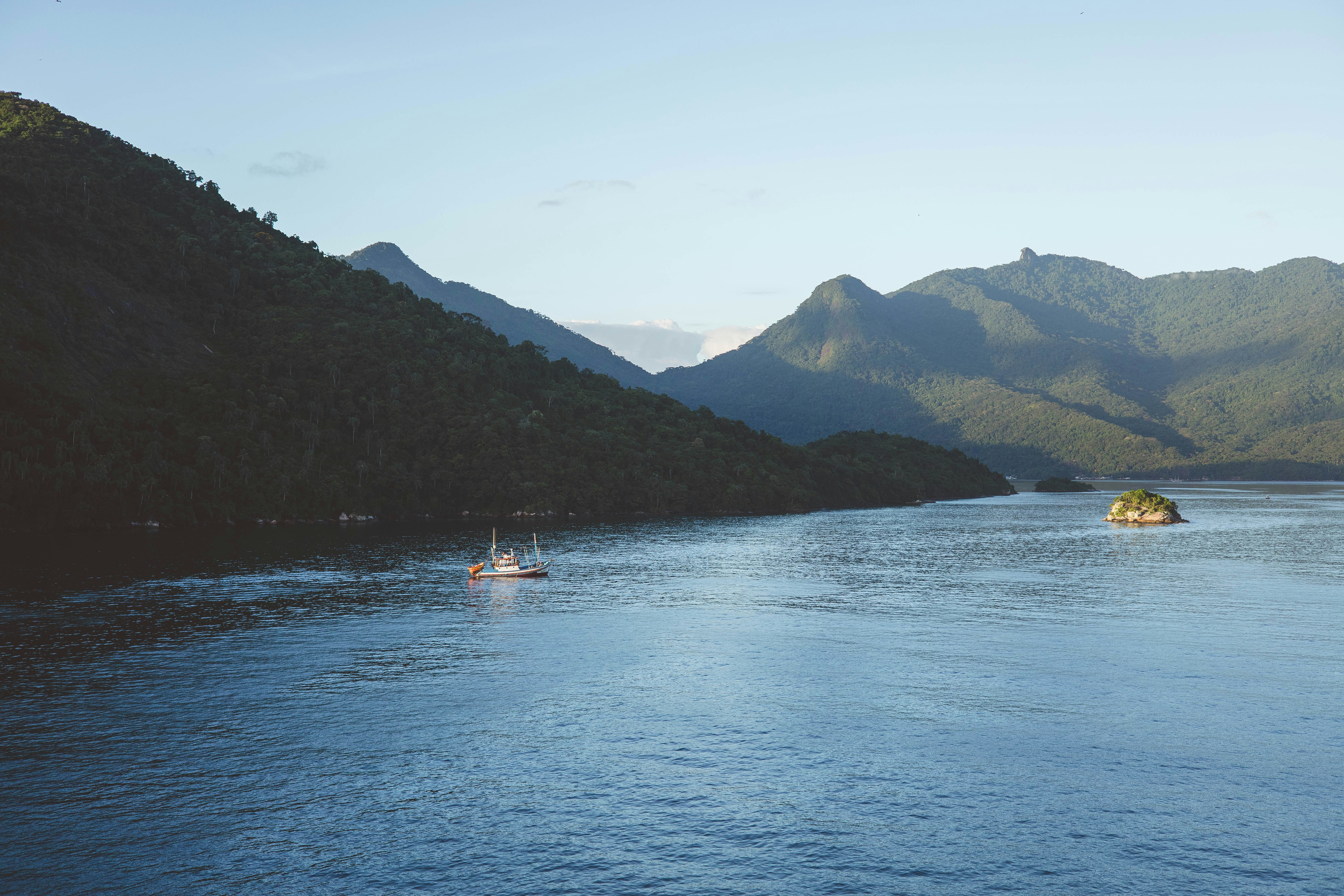 Curtain of Blue: Boats Drift Through Quiet Fjord Under a Mountain Ring