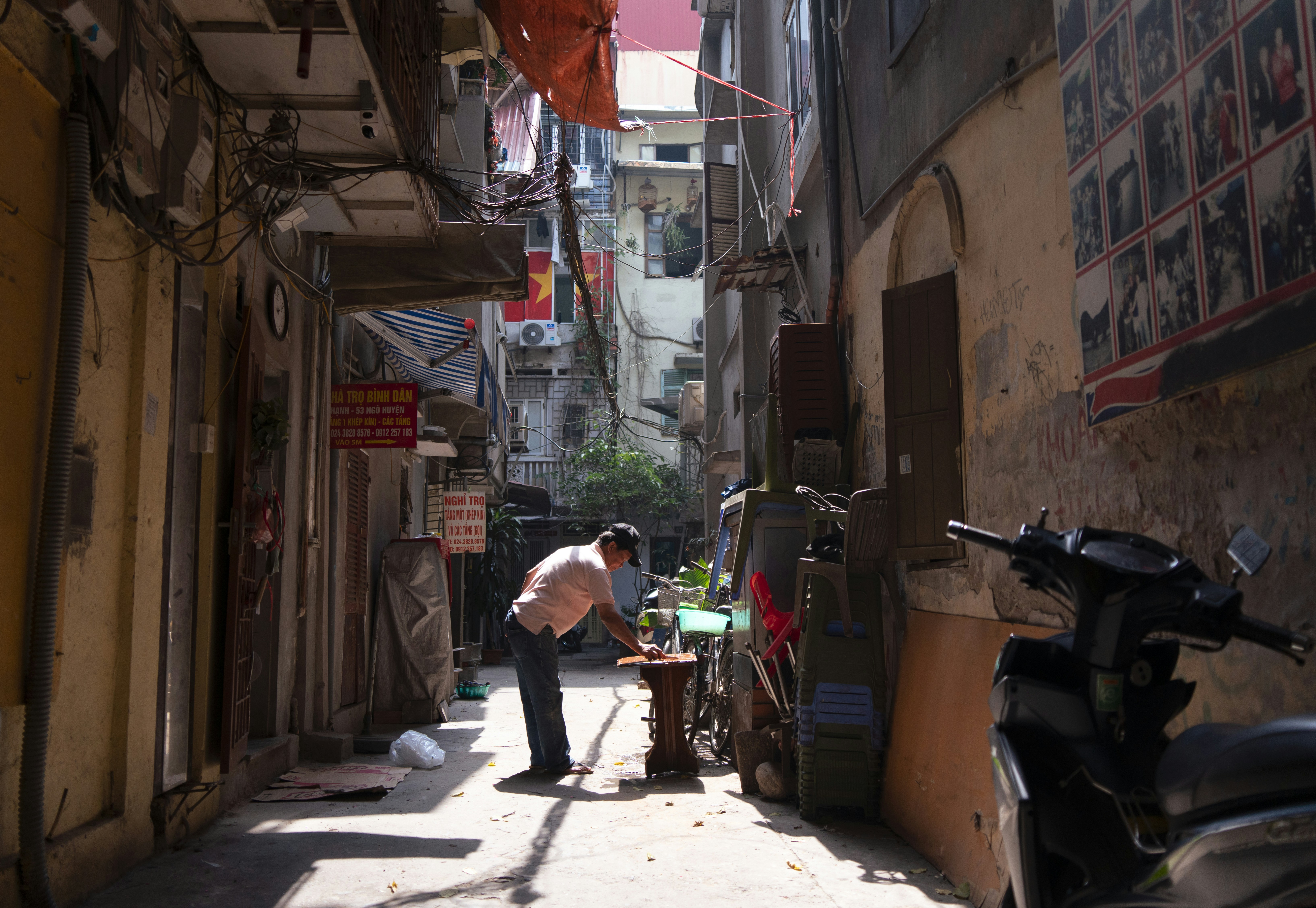 Sunlit Alleyway: A Moment of Work Beneath Narrow Skies