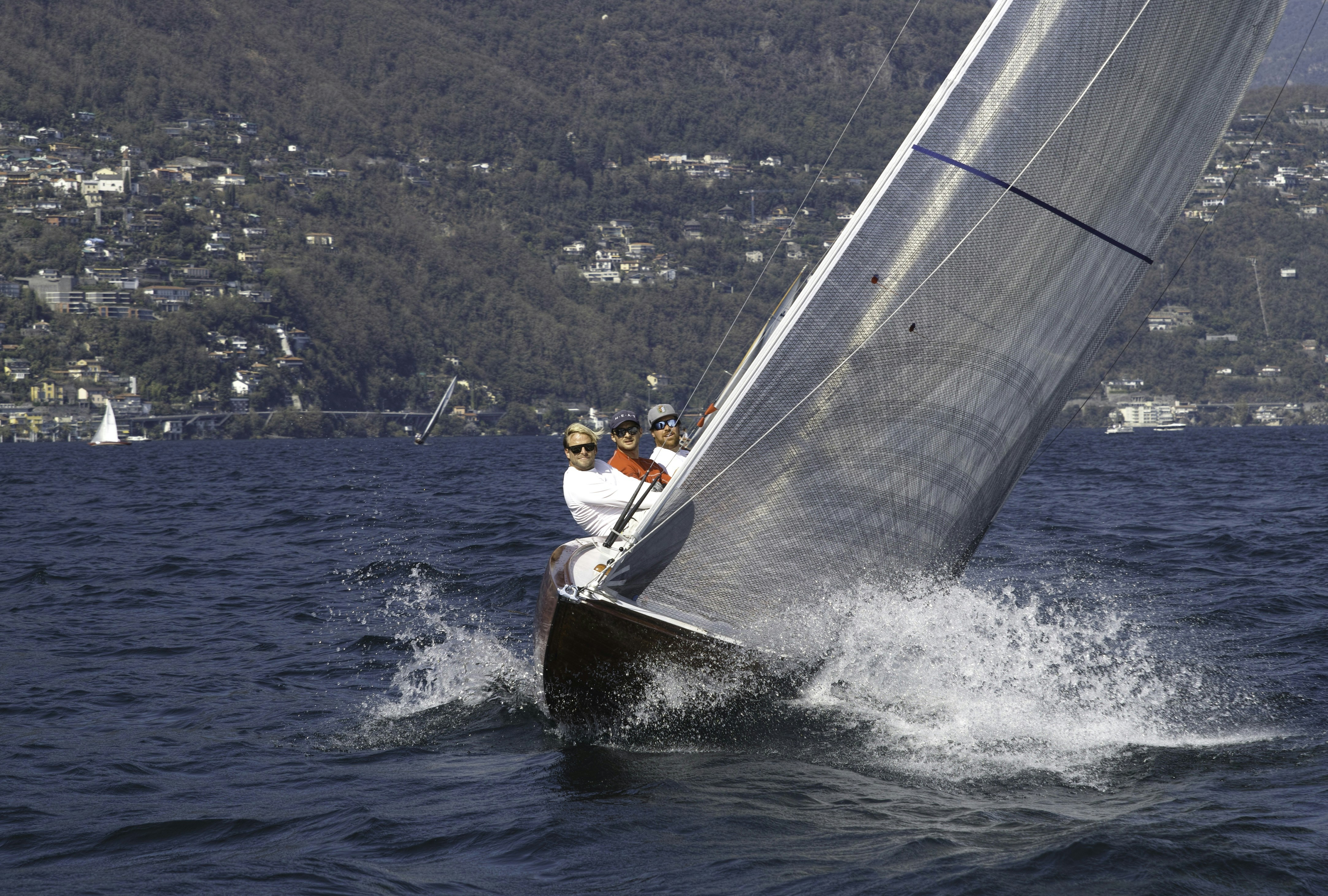 Racing Sails: A Lean, Wind-Pulled Hull Slices Through Blue Wake