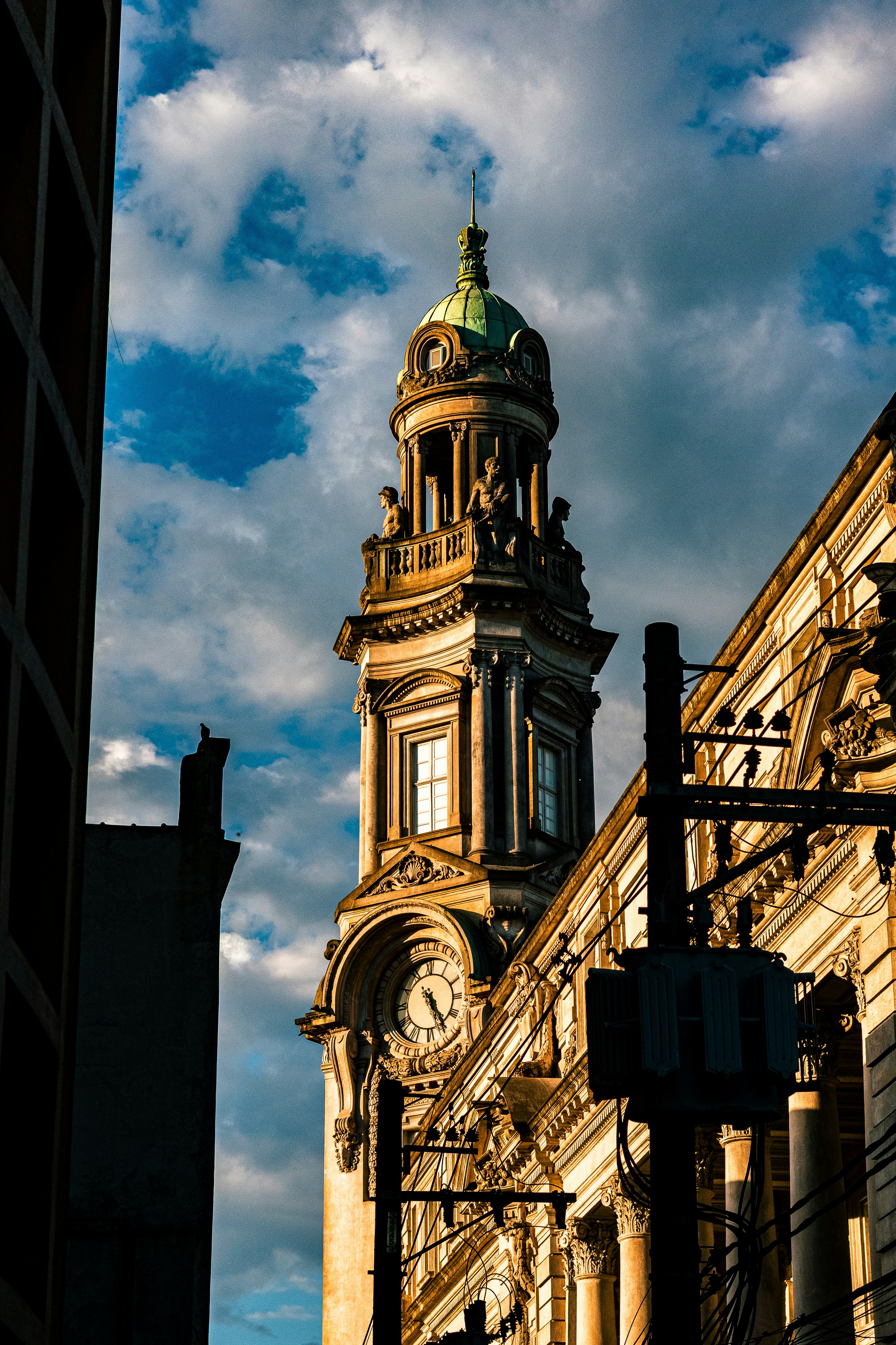 Clock Tower in Urban Sunset: A Stately Facade Framed by Skyline Shadows