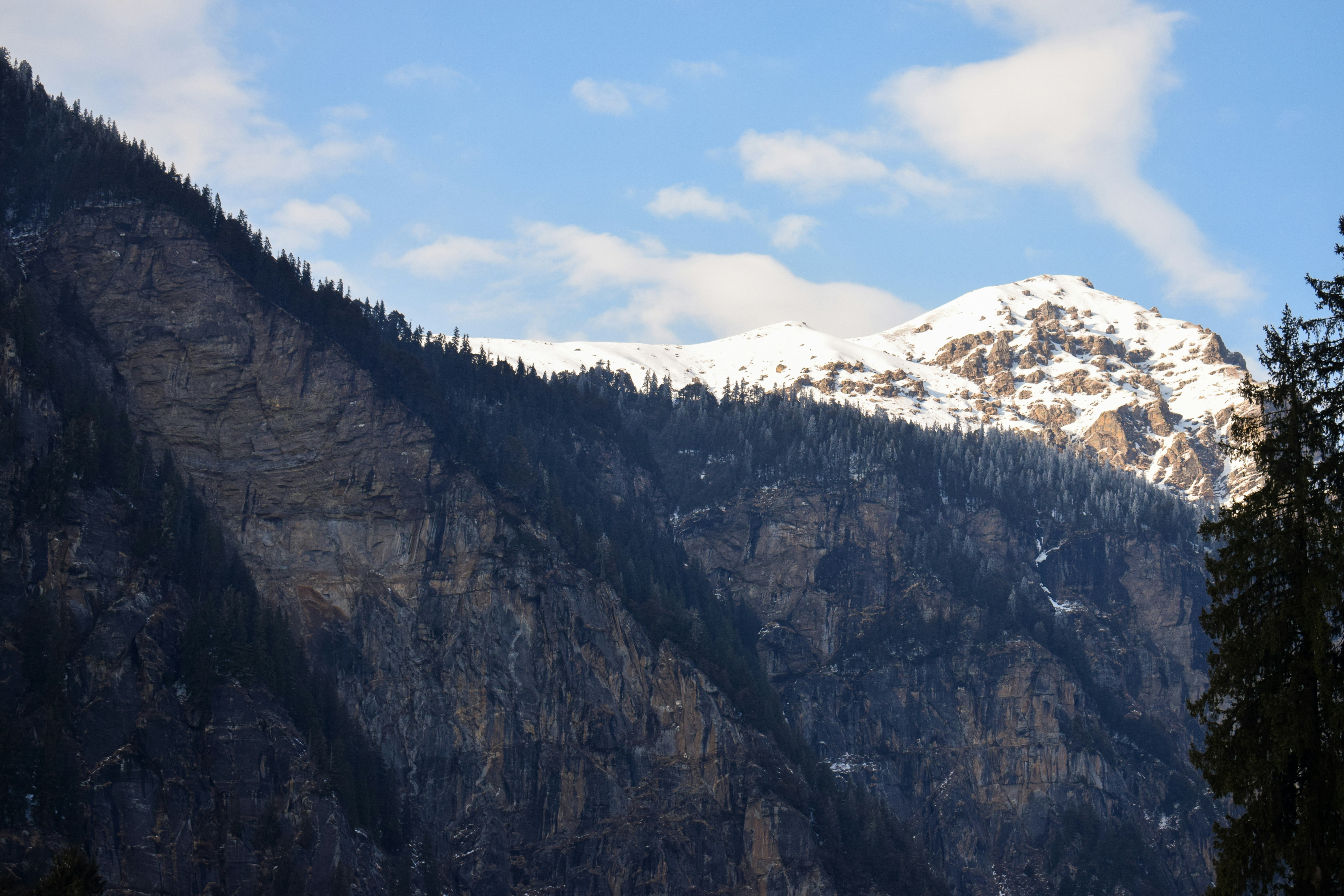 Snow-kissed Peak Against a Carved Mountain Face
