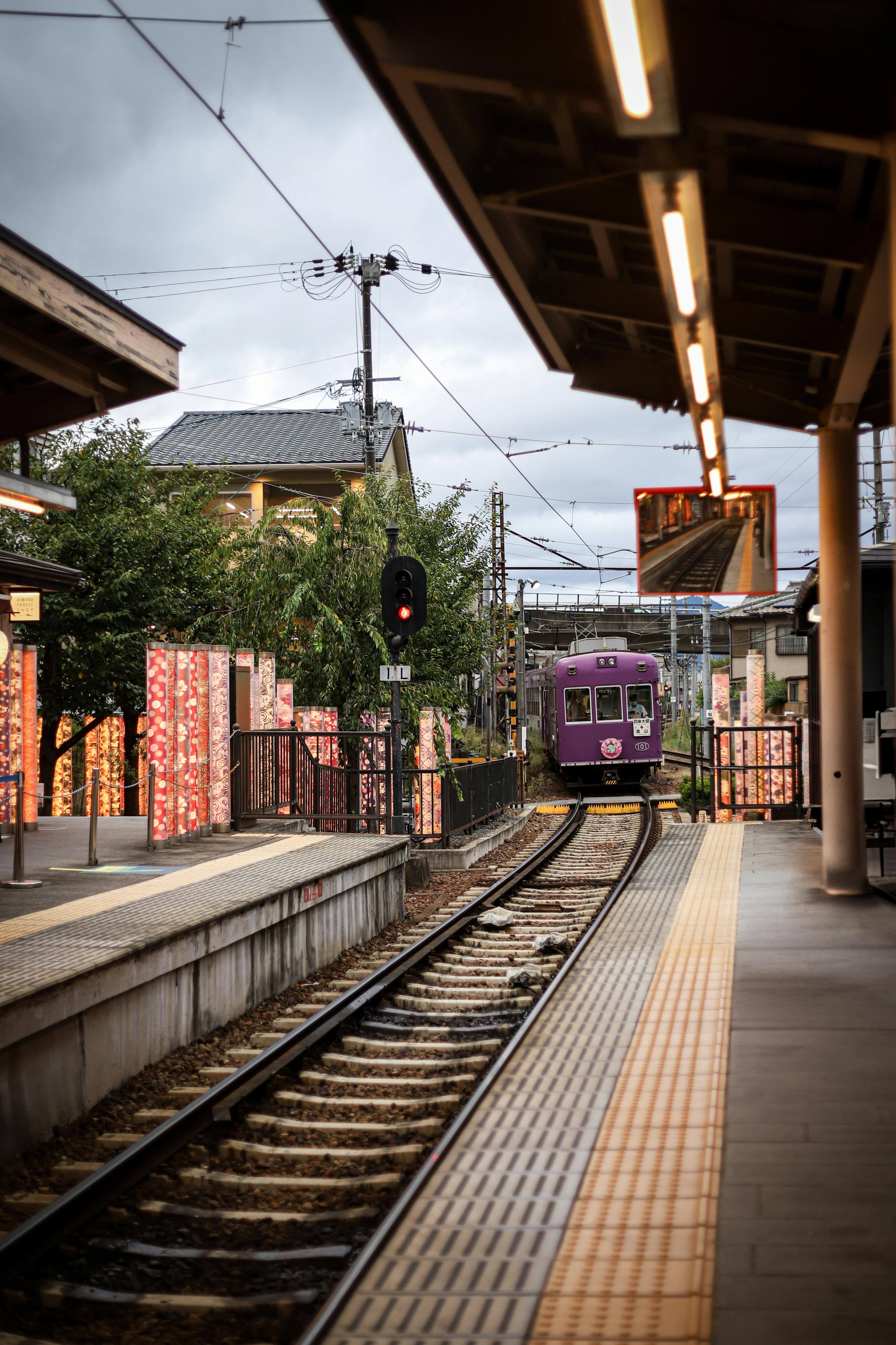 Purple train at a sunlit suburban station