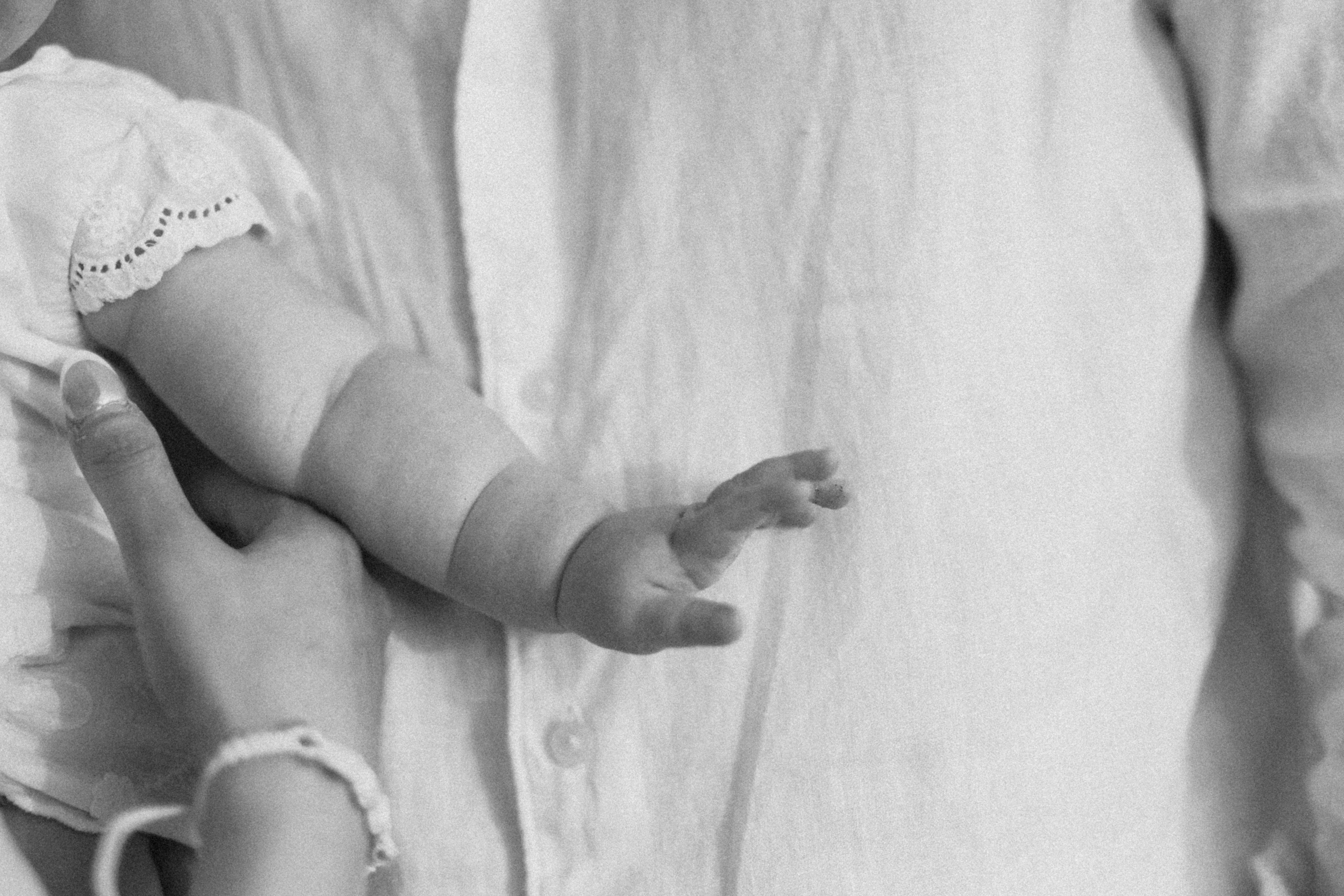 Gentle Hold: A Baby's Arm Resting Against a Soft Shirt