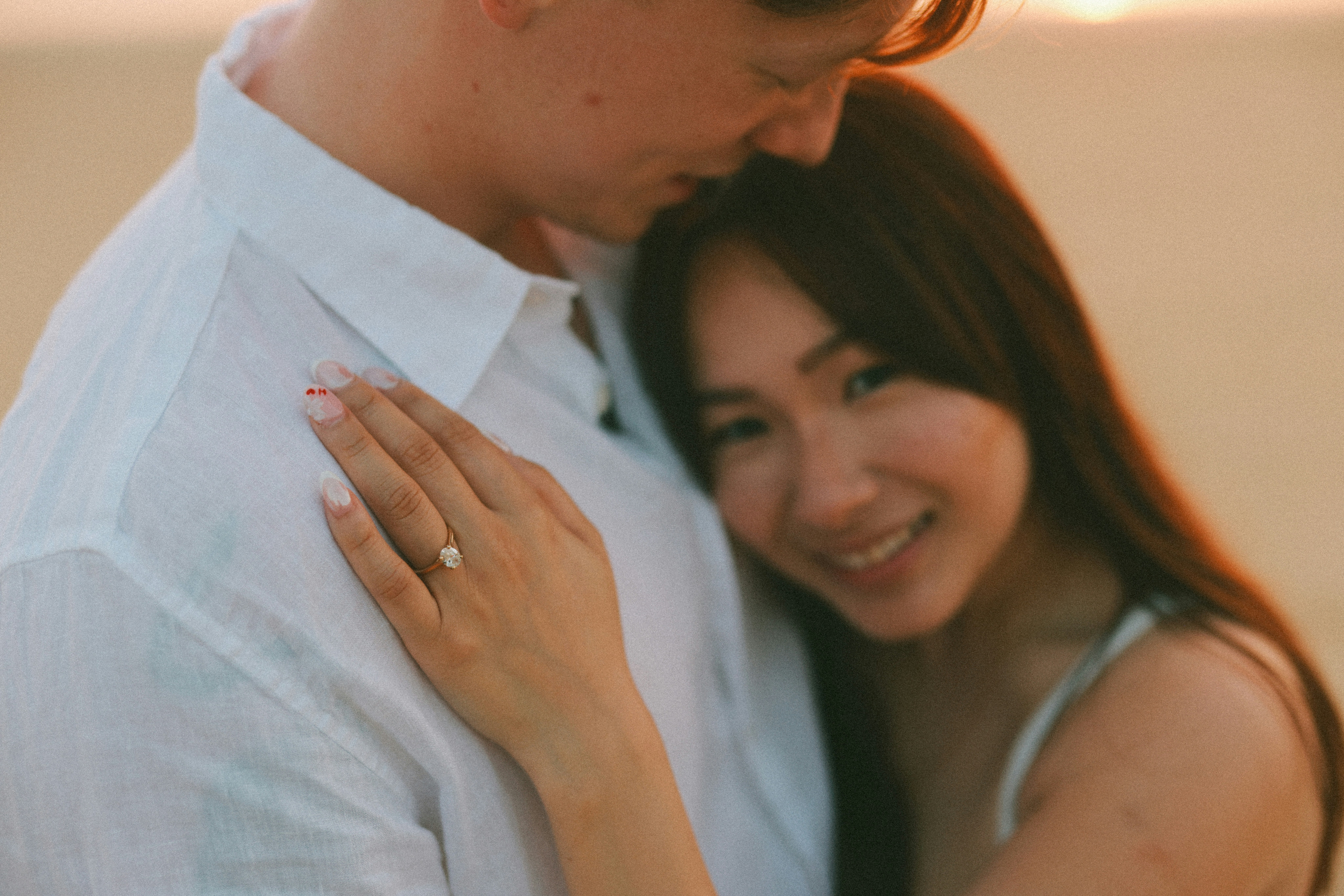 Close embrace: a softly lit engagement ring moment