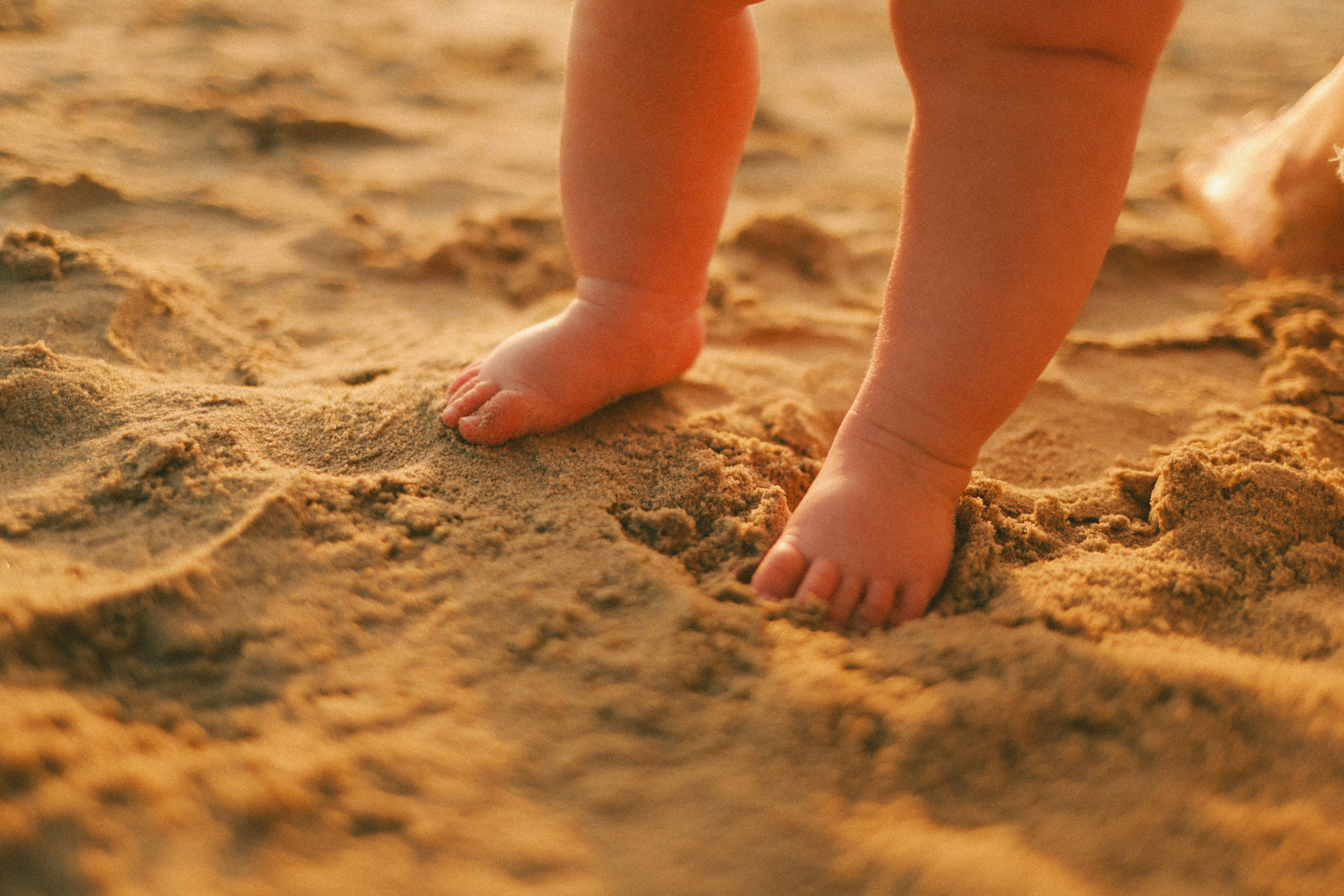Sunlit Tread: Baby Feet in Warm Sand