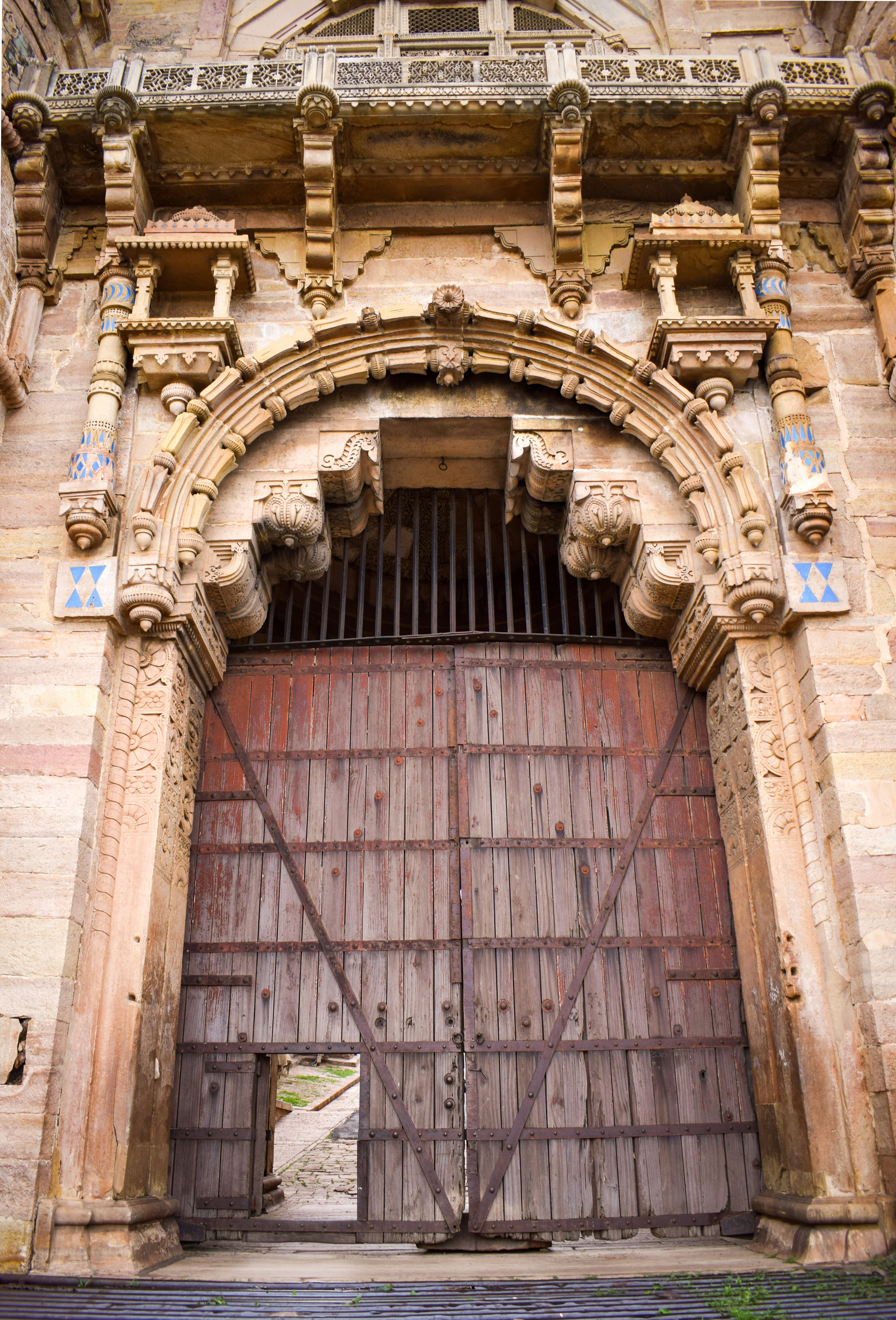 Guardian Arch: Weathered Gate Amidst Ornate Stonework