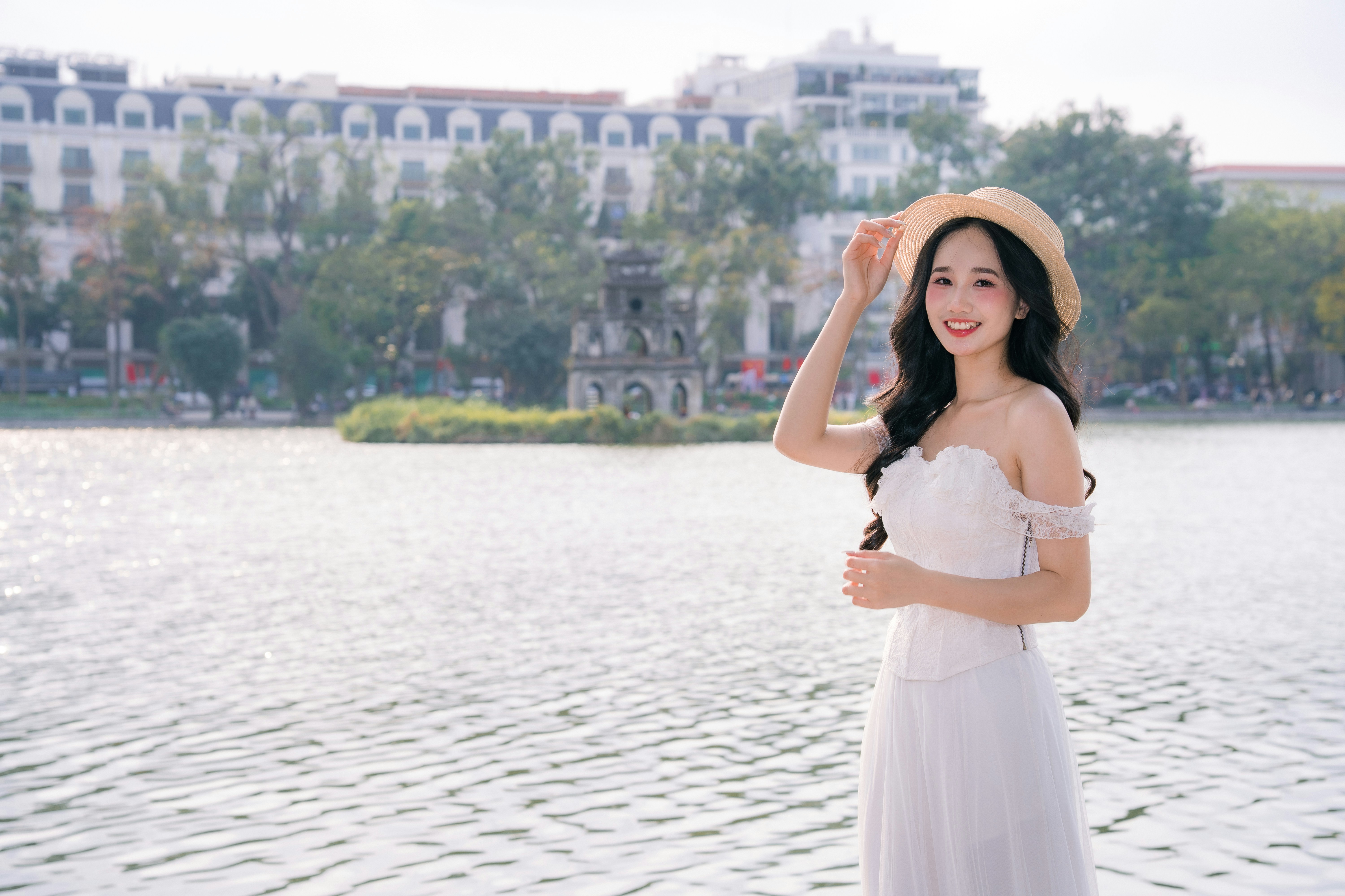 Sunlit Serenade by the Water: A Graceful Pose in White