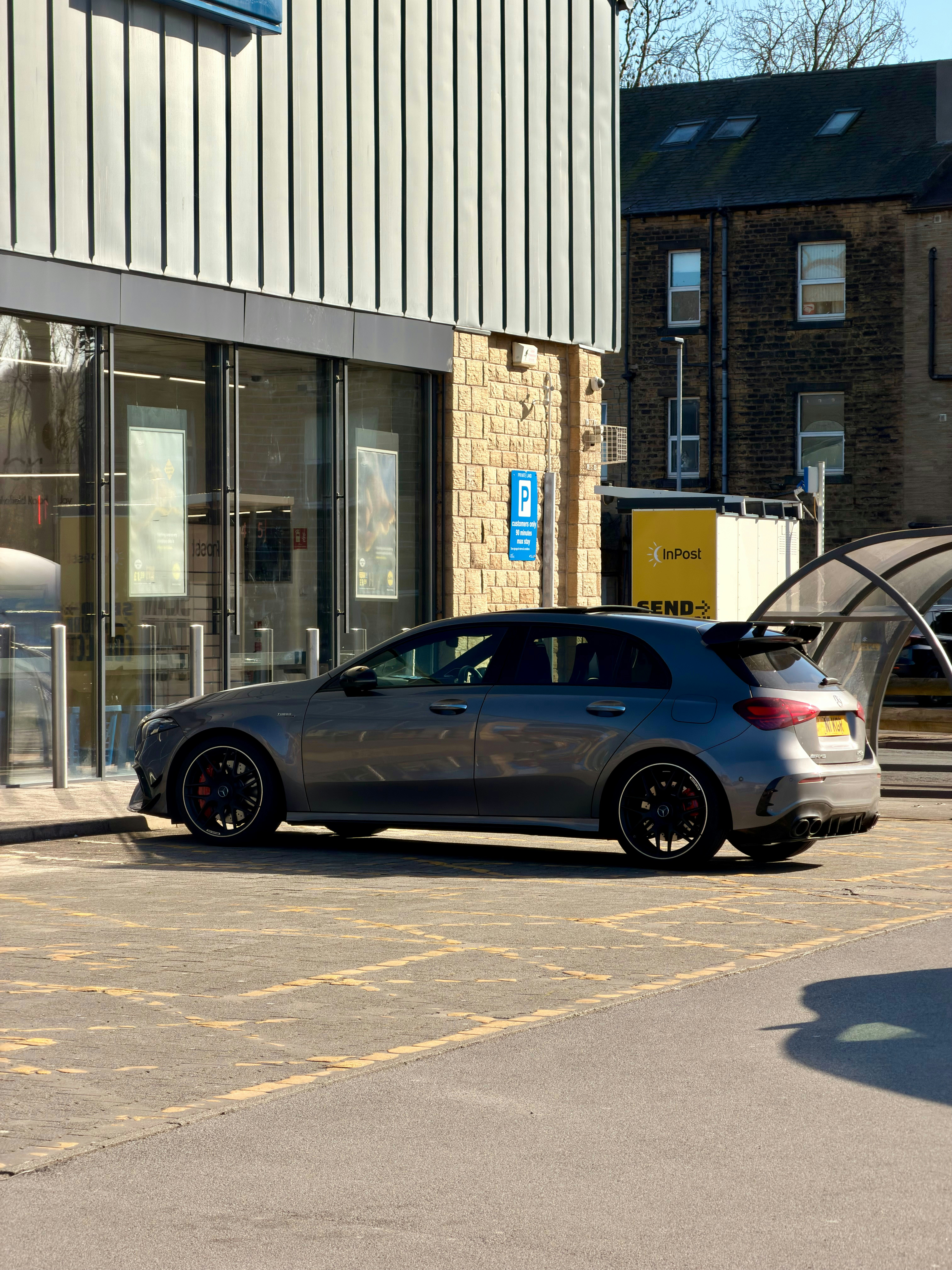 Grey Hatchback at the Edge of a Modern storefront