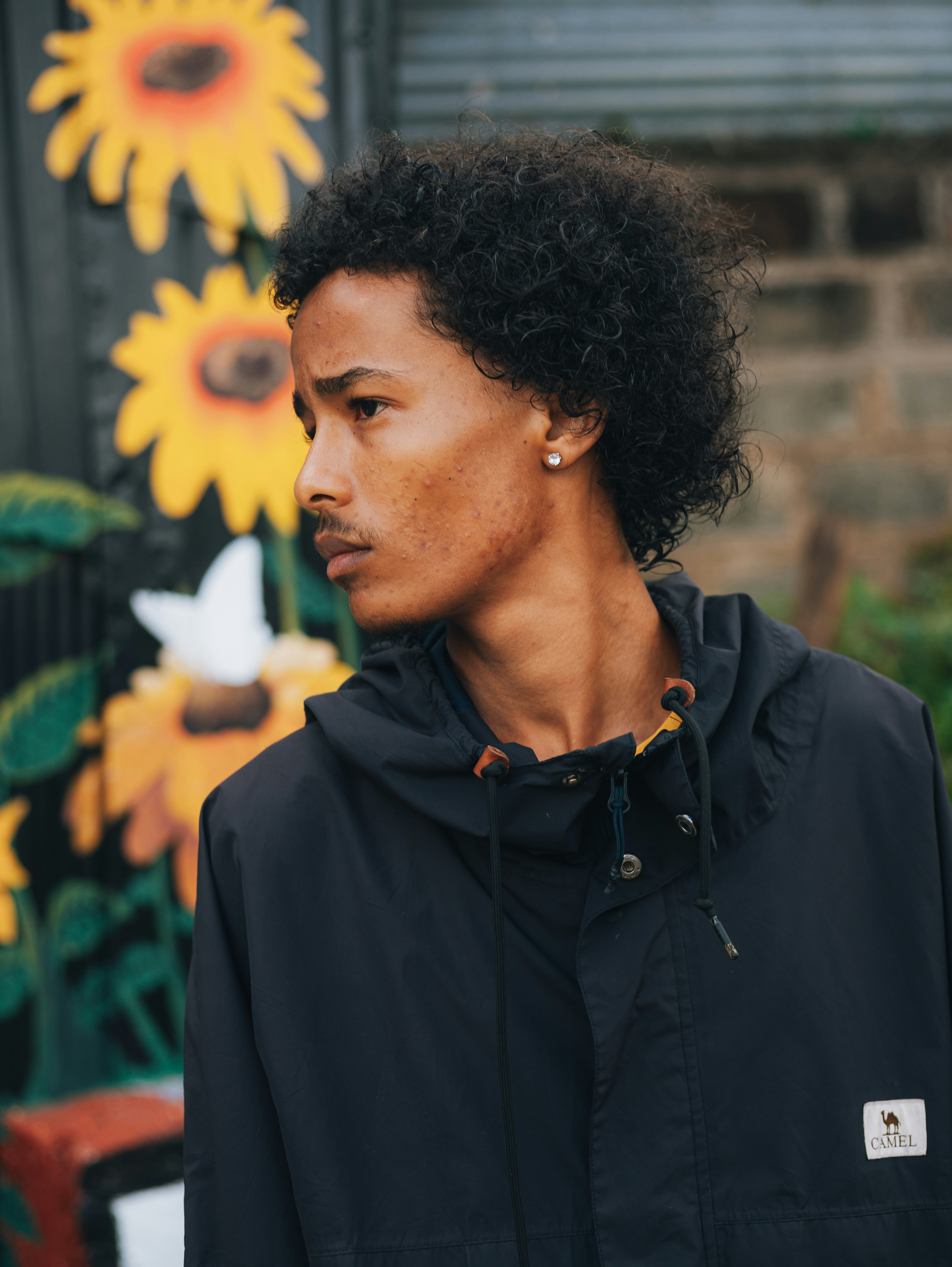 Focused Gaze: A Street Portrait with Sunflowers in Soft Evening Light