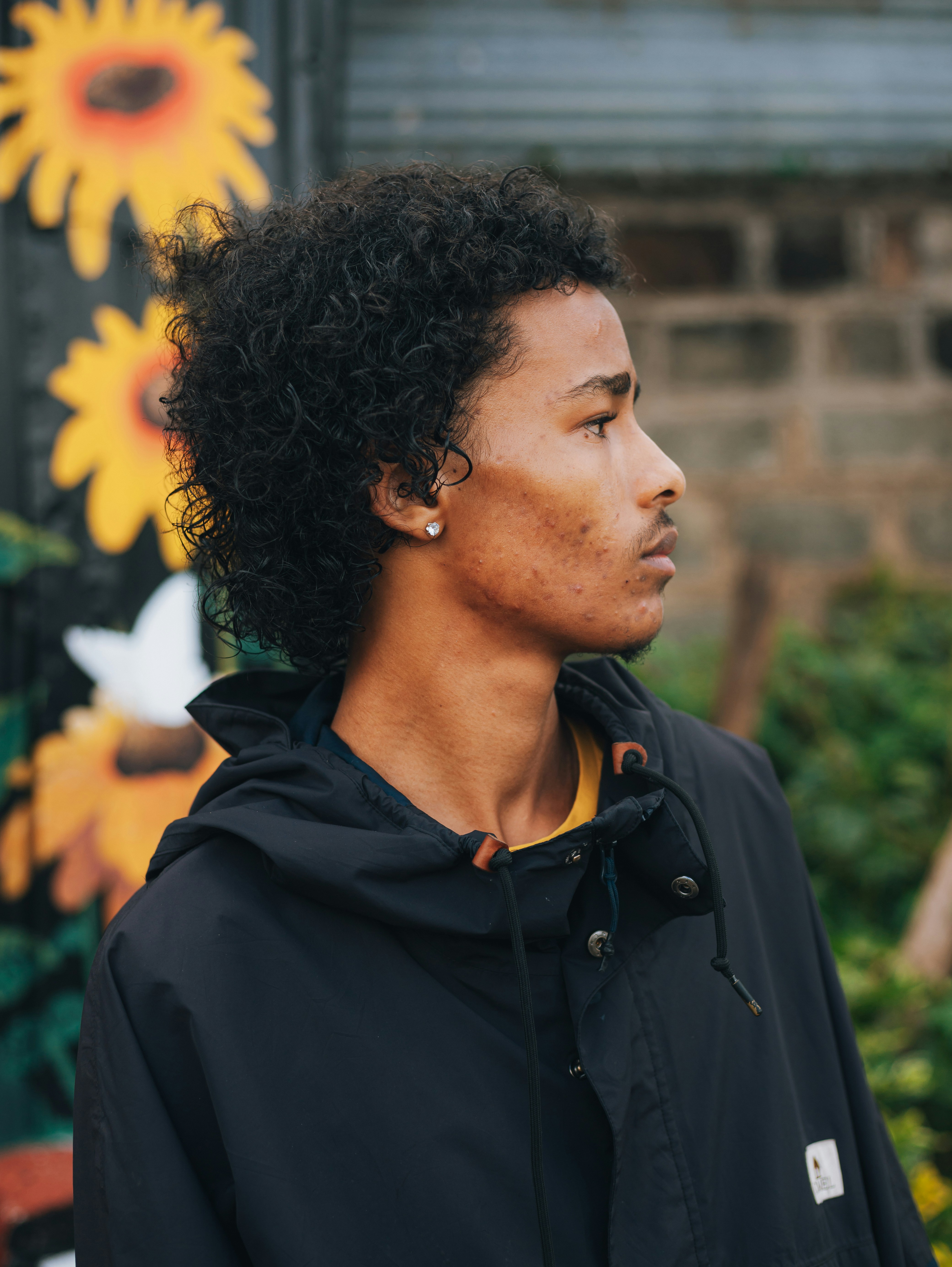 Portrait in Profile: Quiet Strength Against a Sunflower Wall