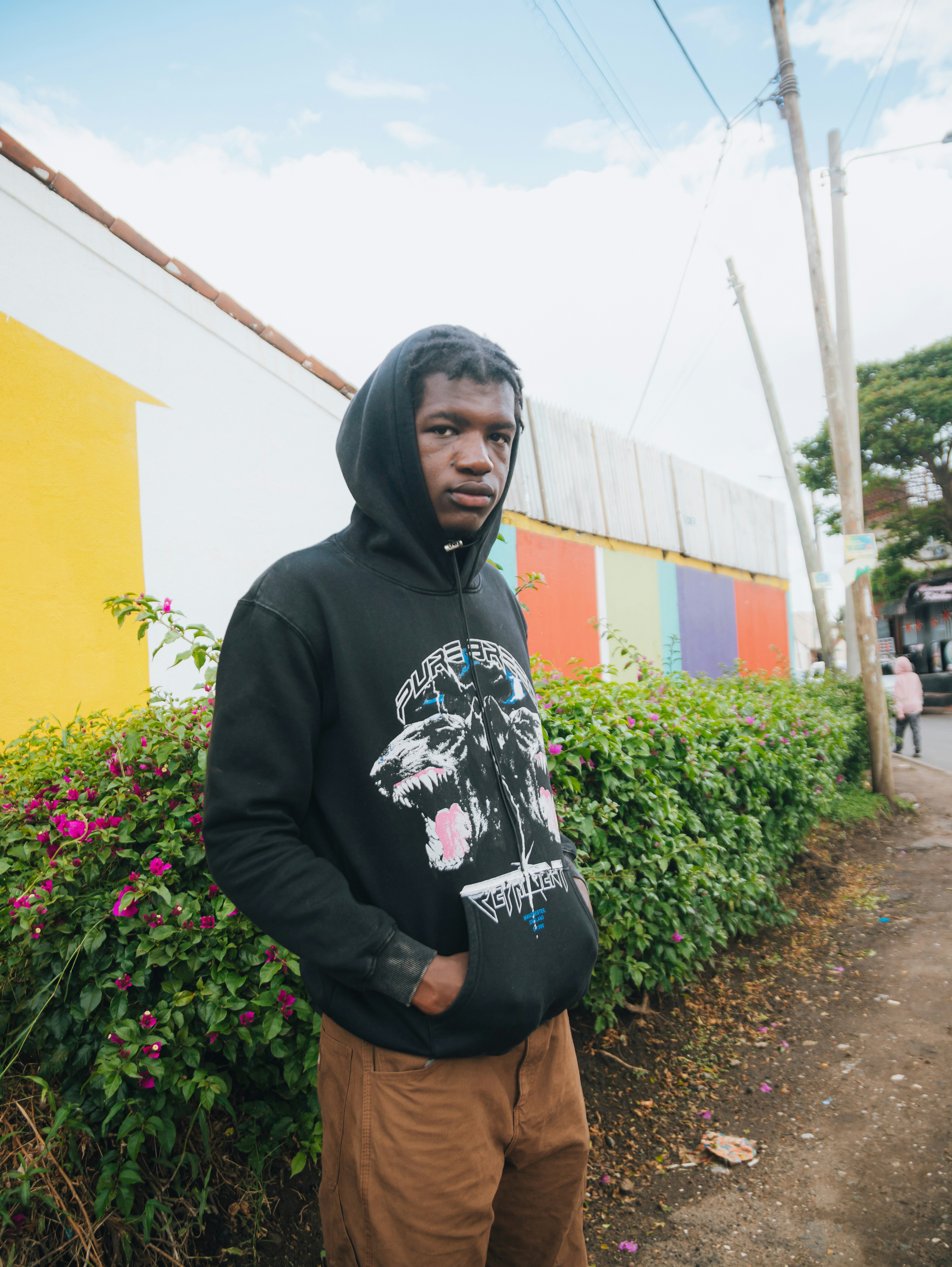 Pastel Wall, Shadowed Hoodie: Street Portrait in Colorful Alley
