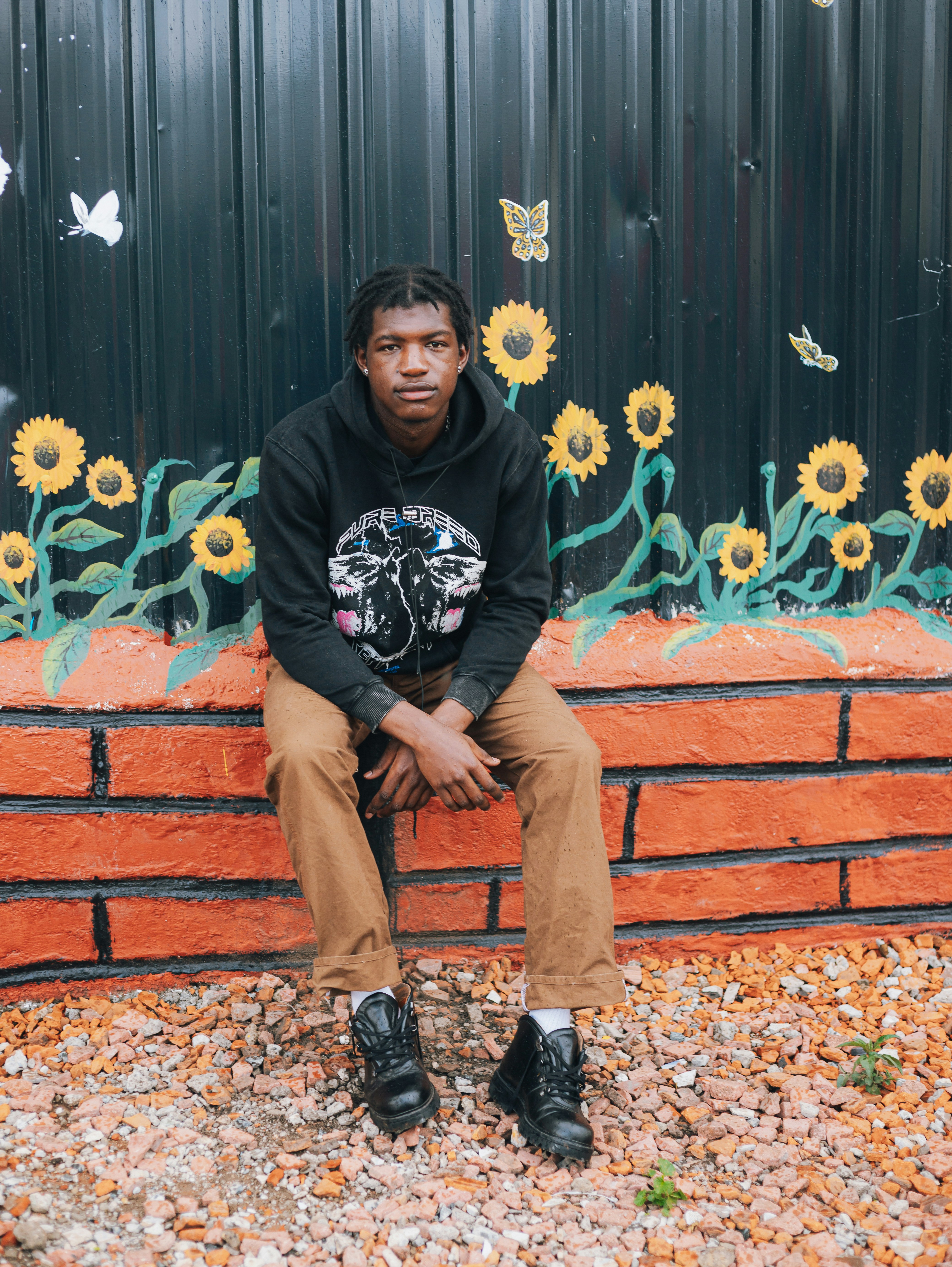 Portrait on a Sunflower Wall: Quiet Confidence Amid Painted Fields
