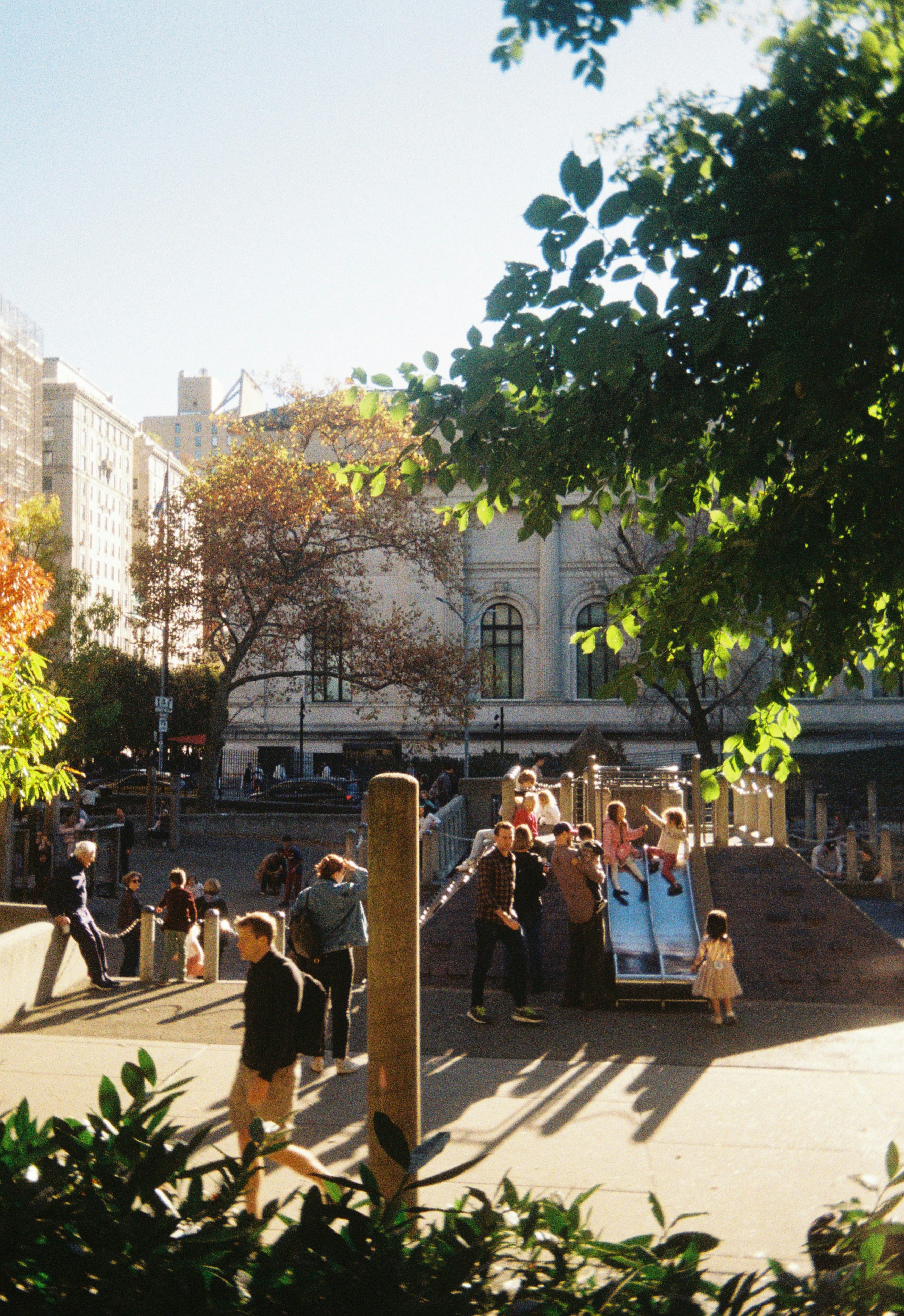 Children at Playfall: A Sunlit City Playground Scene