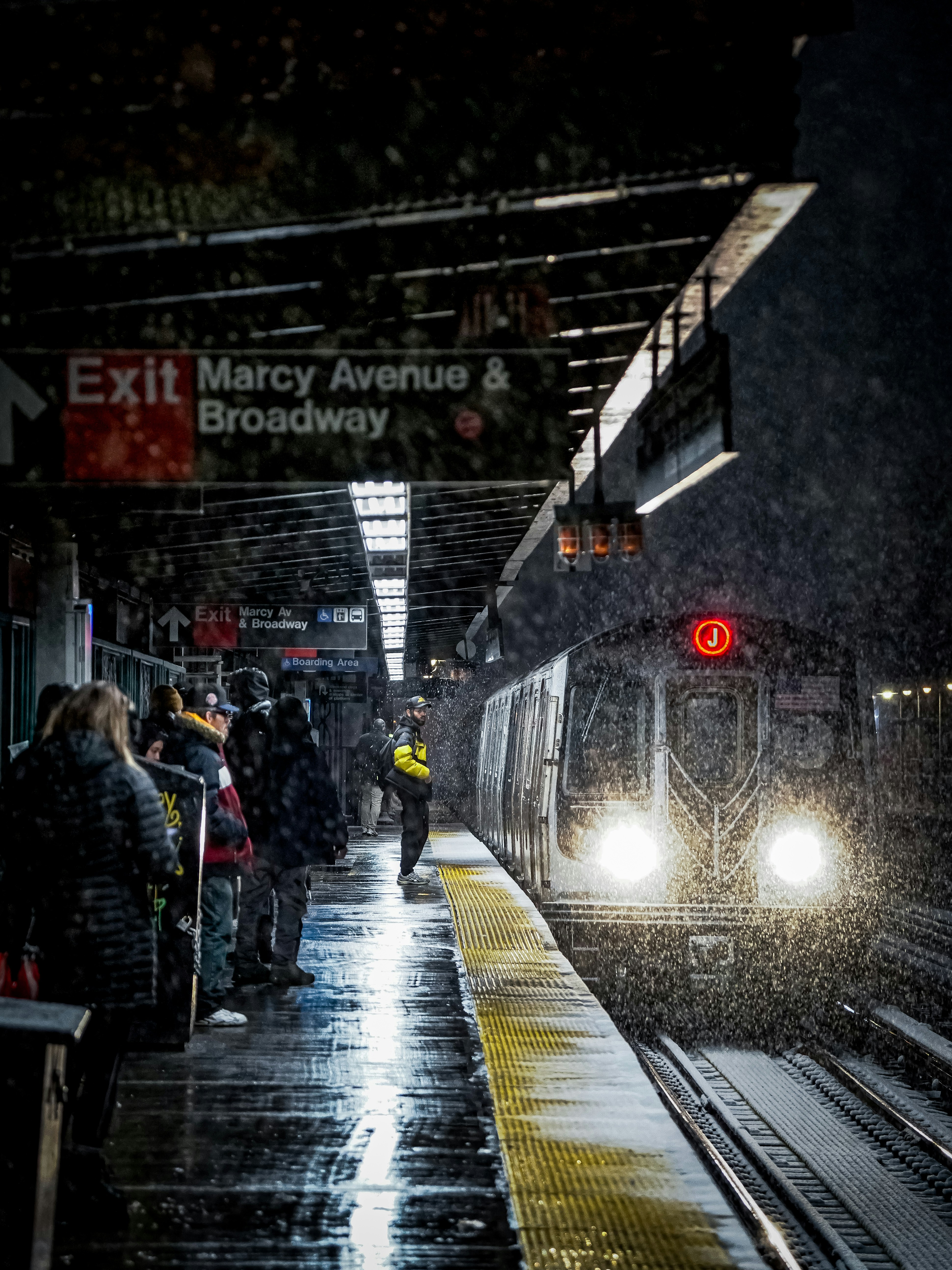 Red J Shuttle arrives: snow-lit platform scene at a city subway station