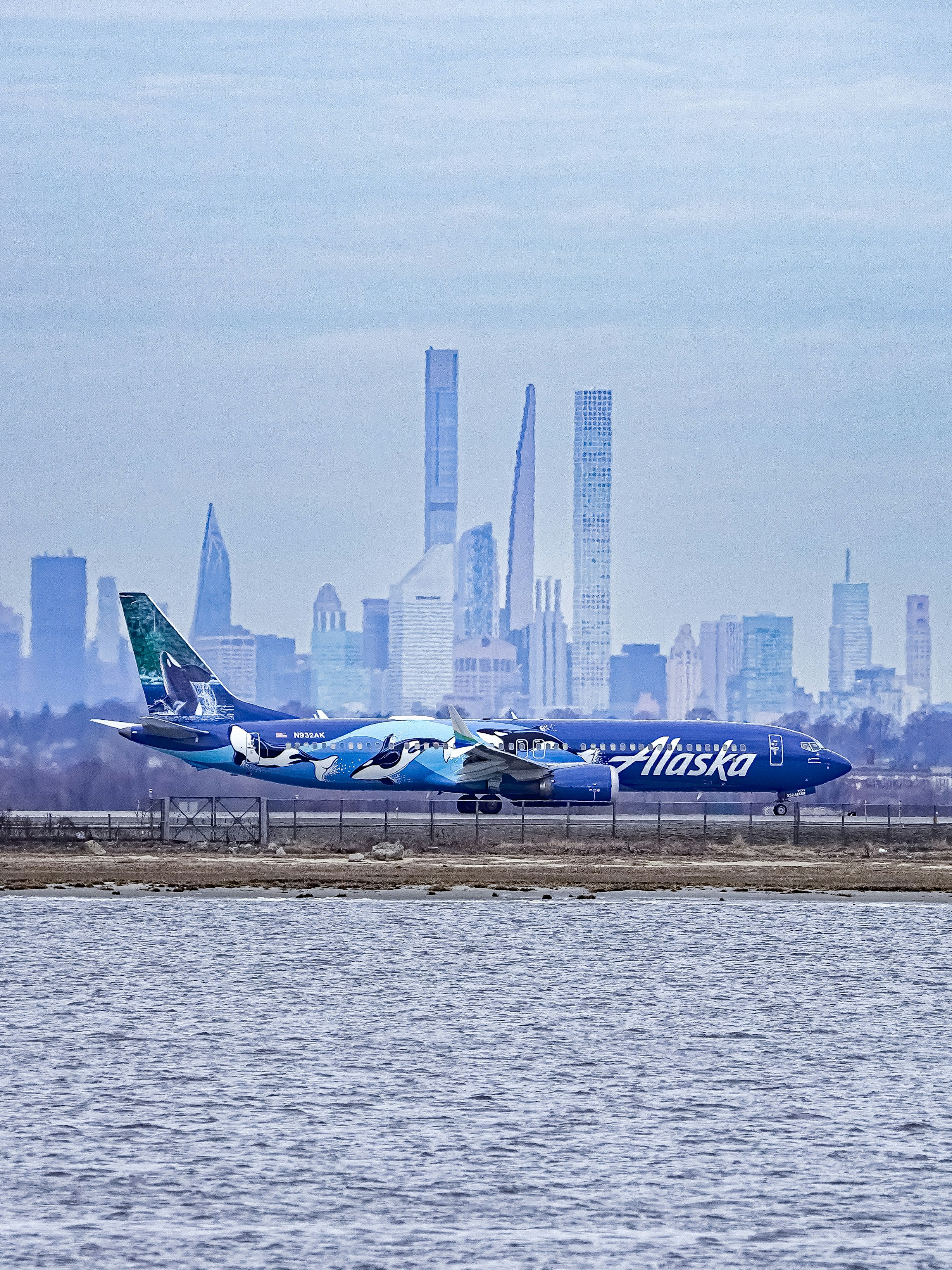 Alaska Pride on the Tarmac: Blue Birds Against a City Backdrop