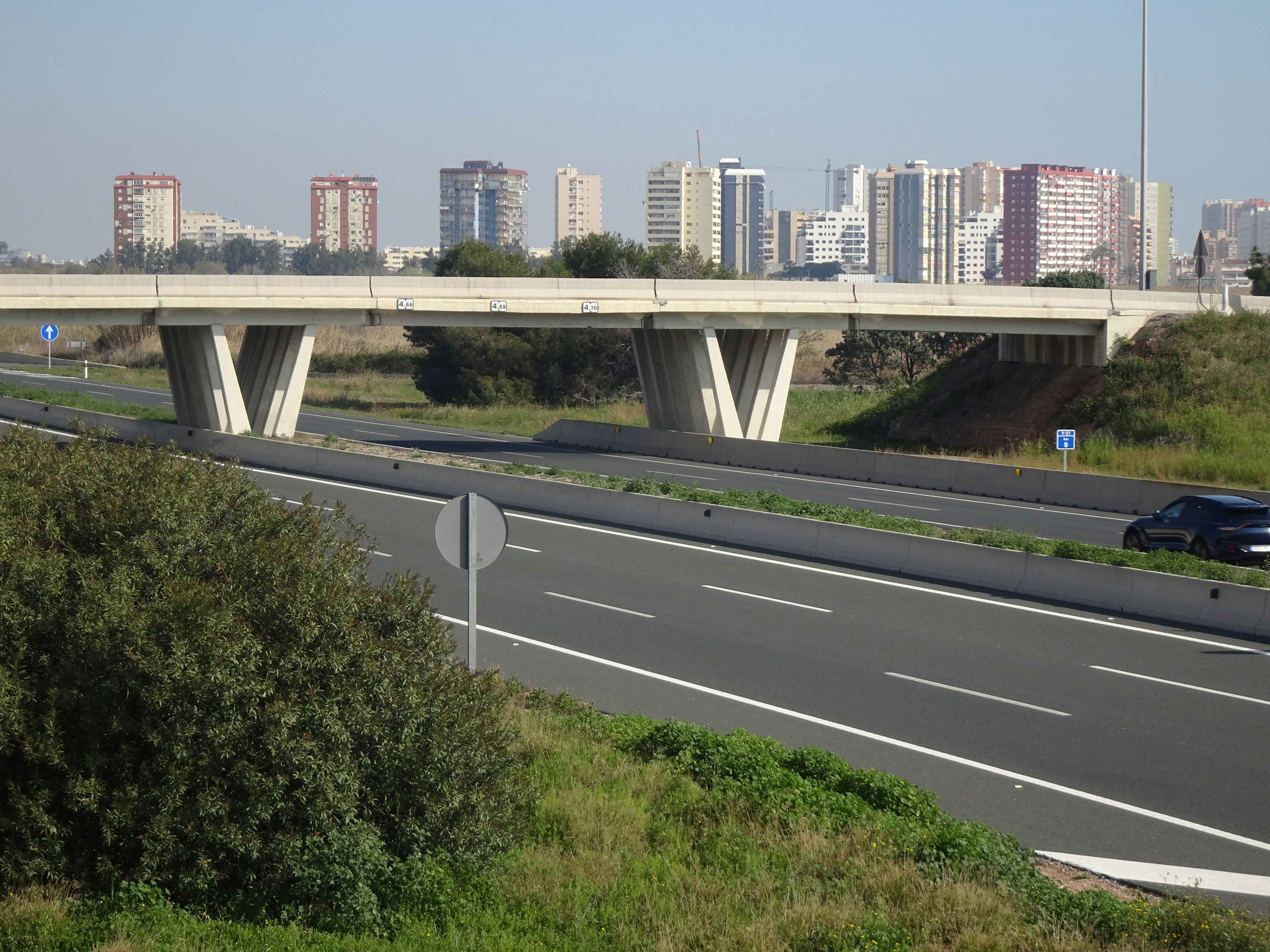 Overpass Echoes: Cityscape Behind a Serene Highway Sweep