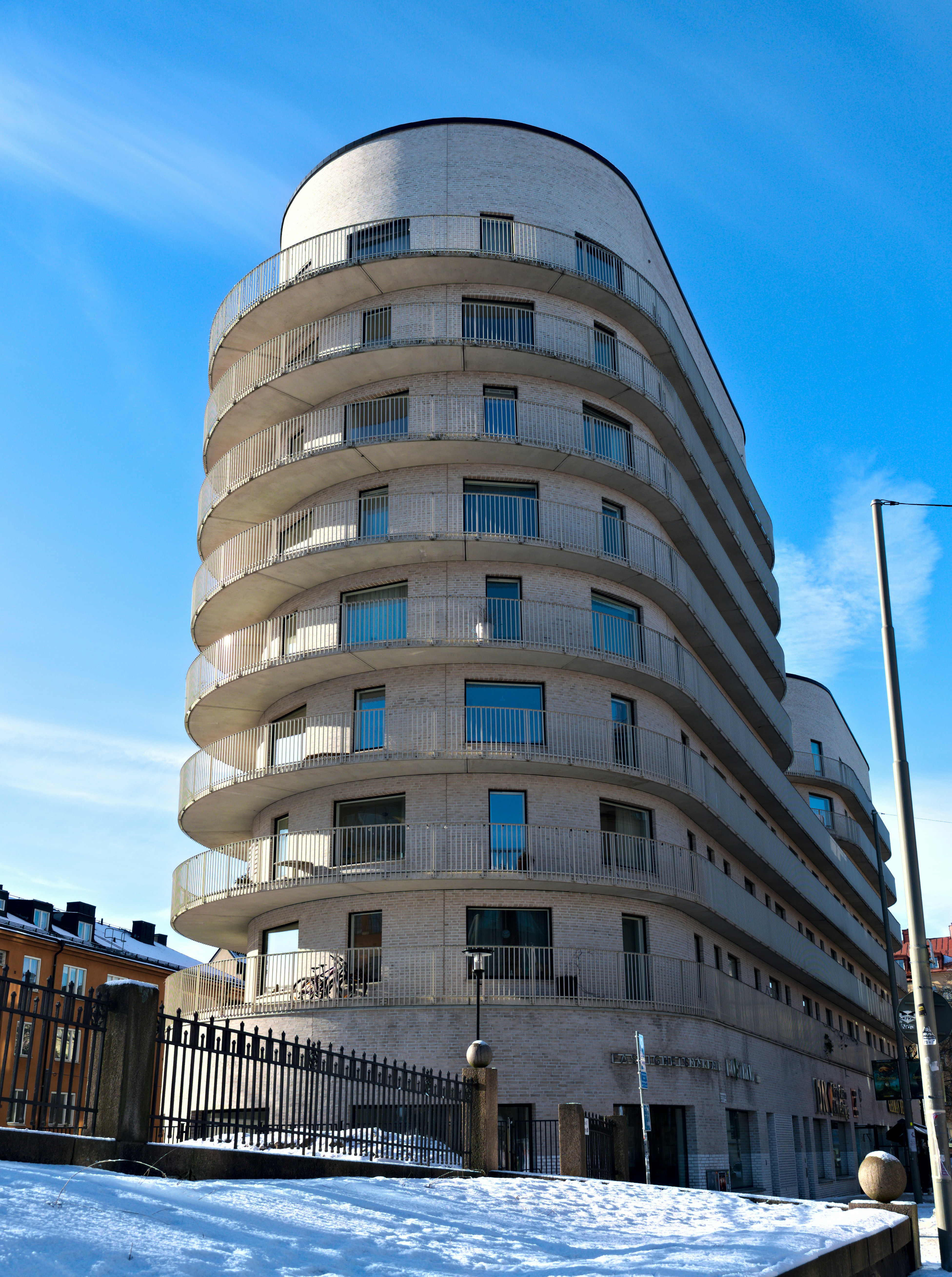 Curved Facade of a White Apartment Tower Reaching Toward a Bright Sky