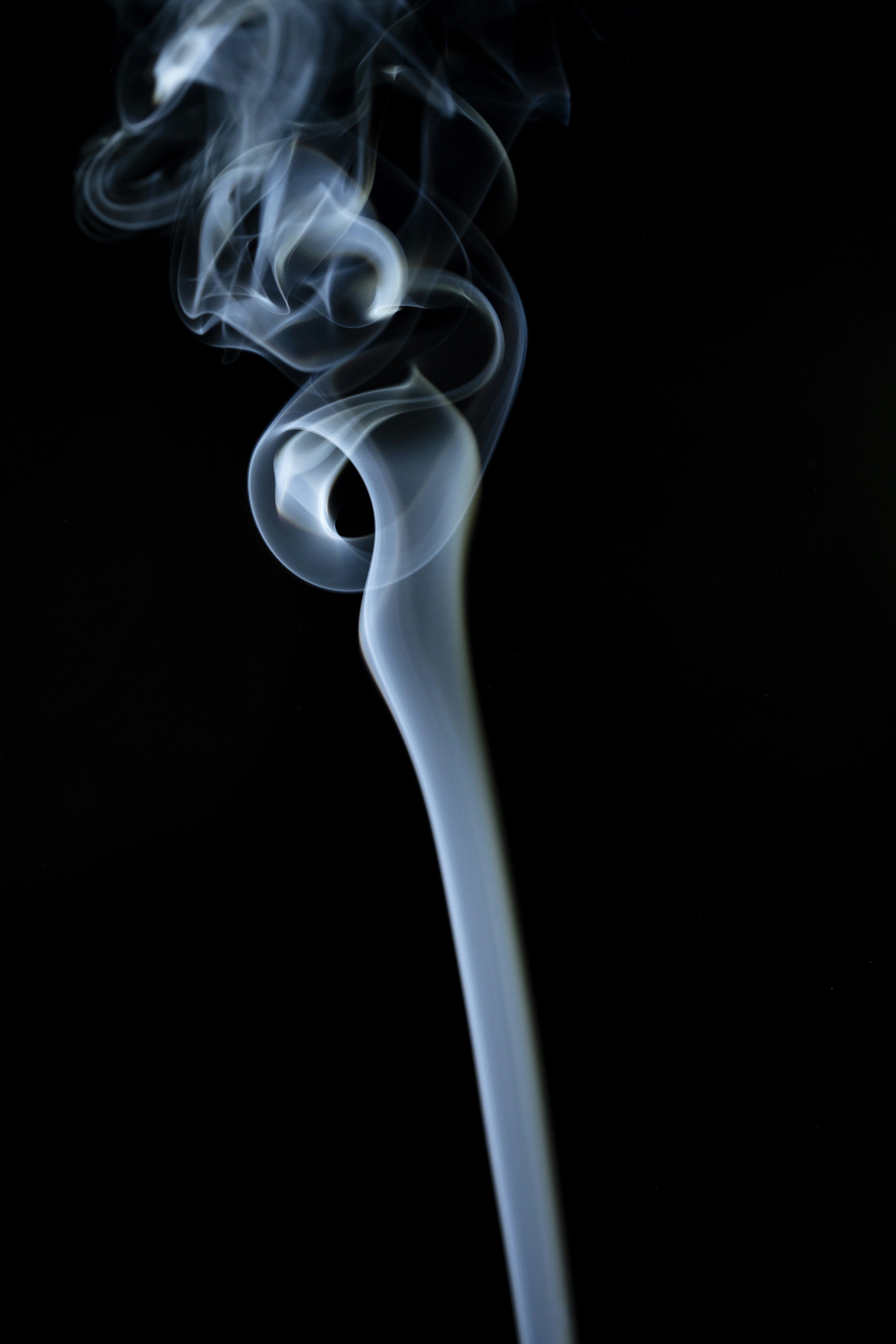 Coil of Smoke: A Delicate Spiral of Light Against Night