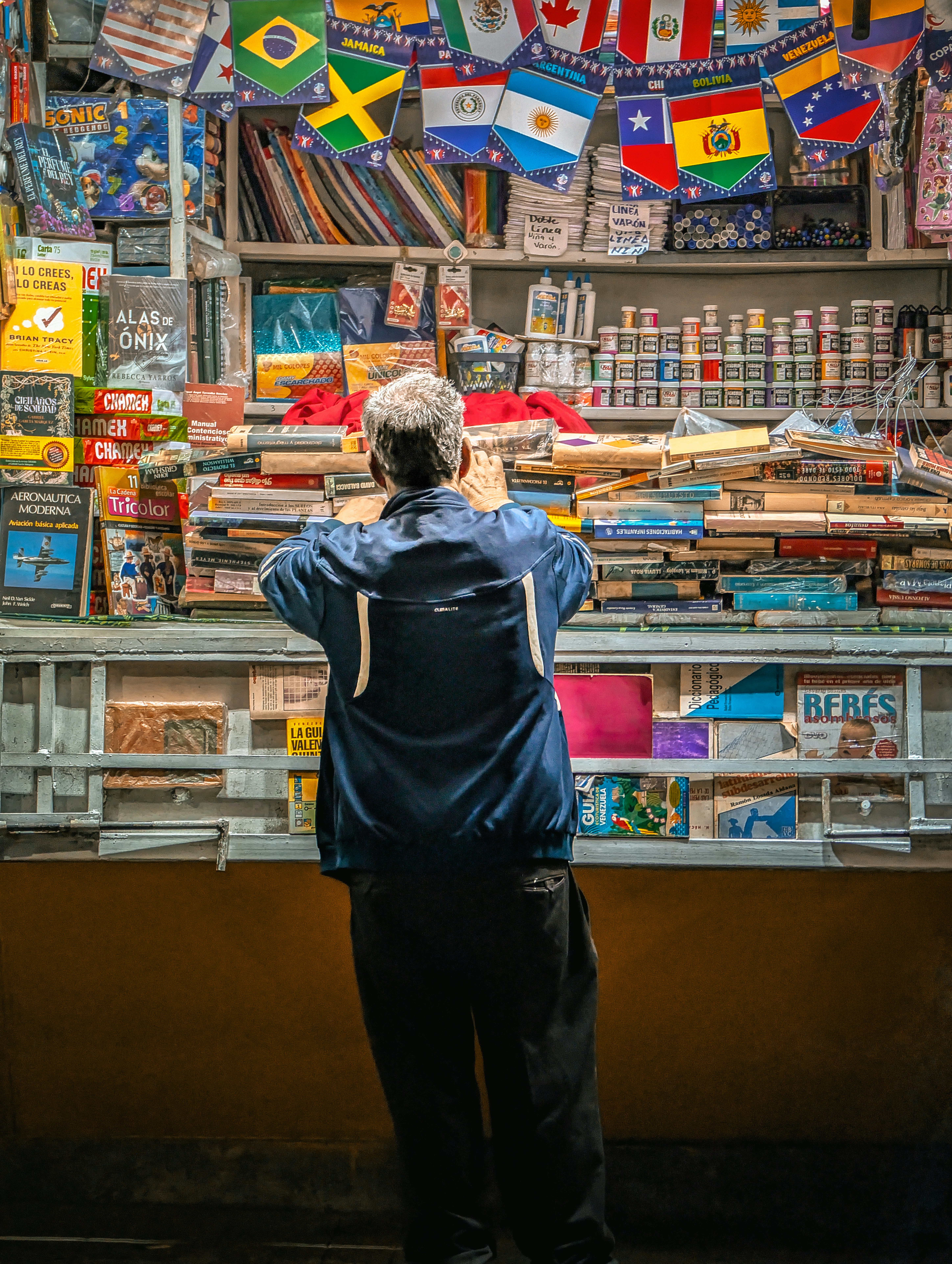 Courier of Color: A Quiet Moment Behind a Wall of Flags