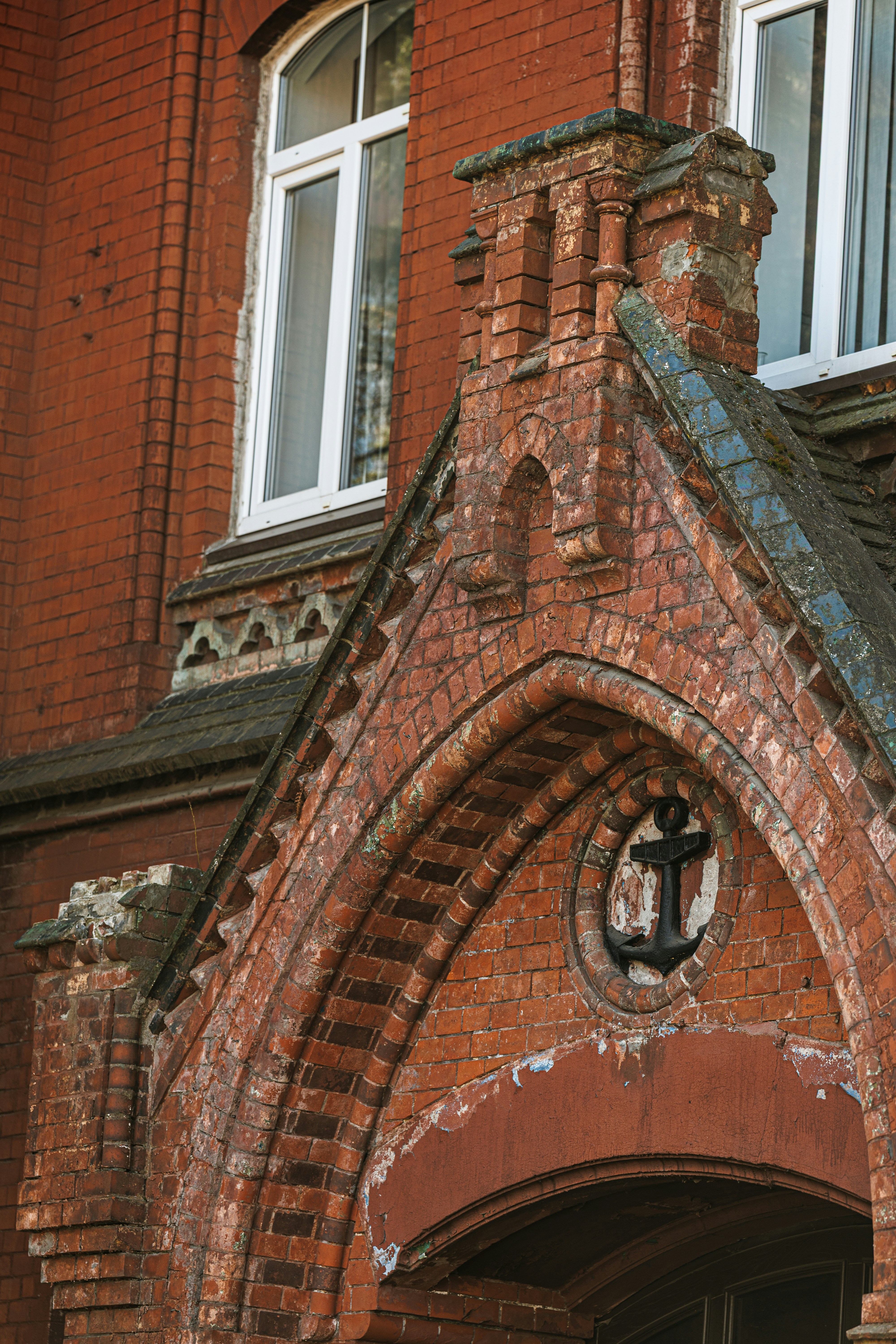 Brick Archway with Anchored Emblem: A Weathered Gable Gesture