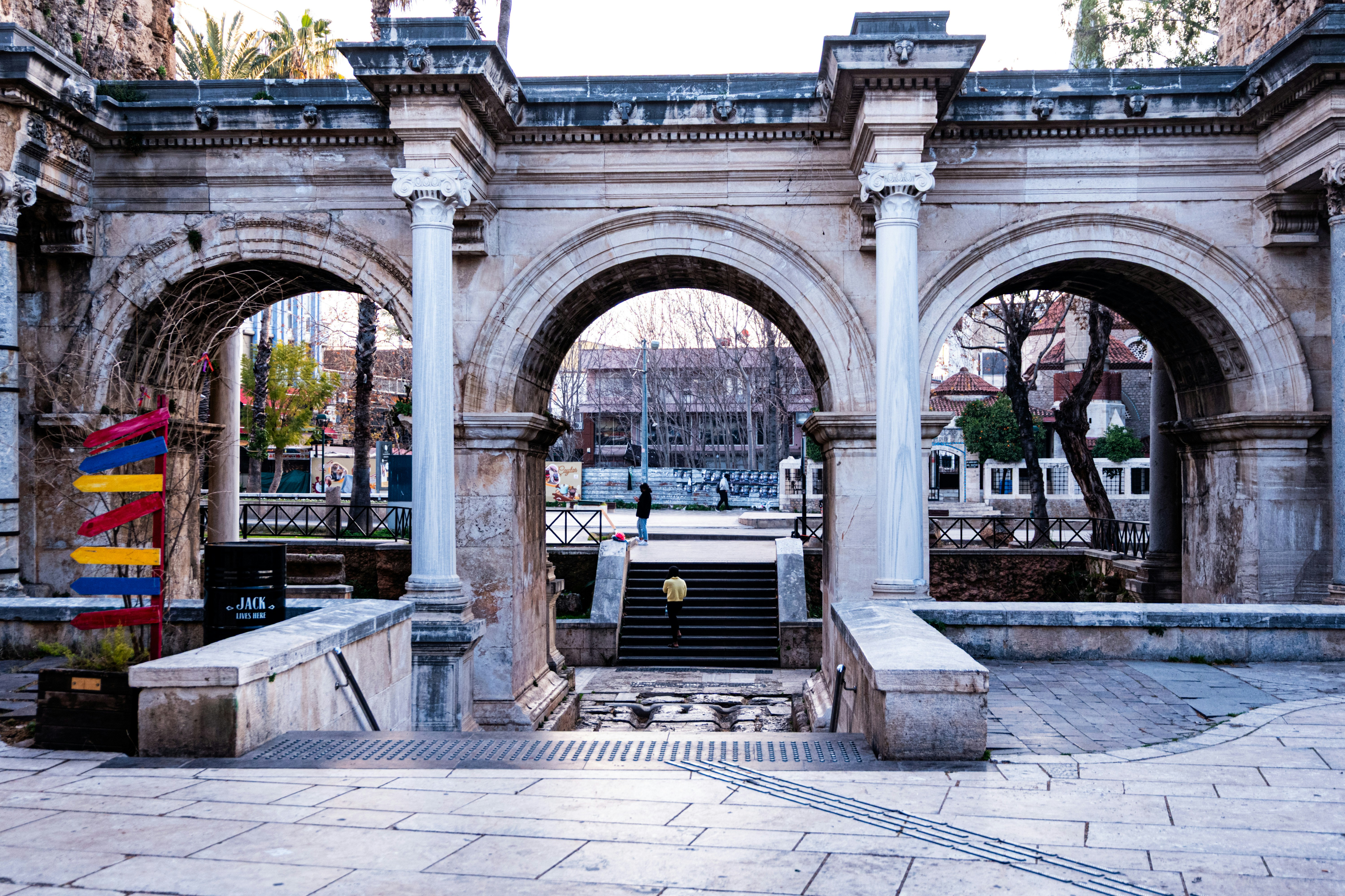 Guardian Arches: Stone Corridor Framed by Historic Pergola