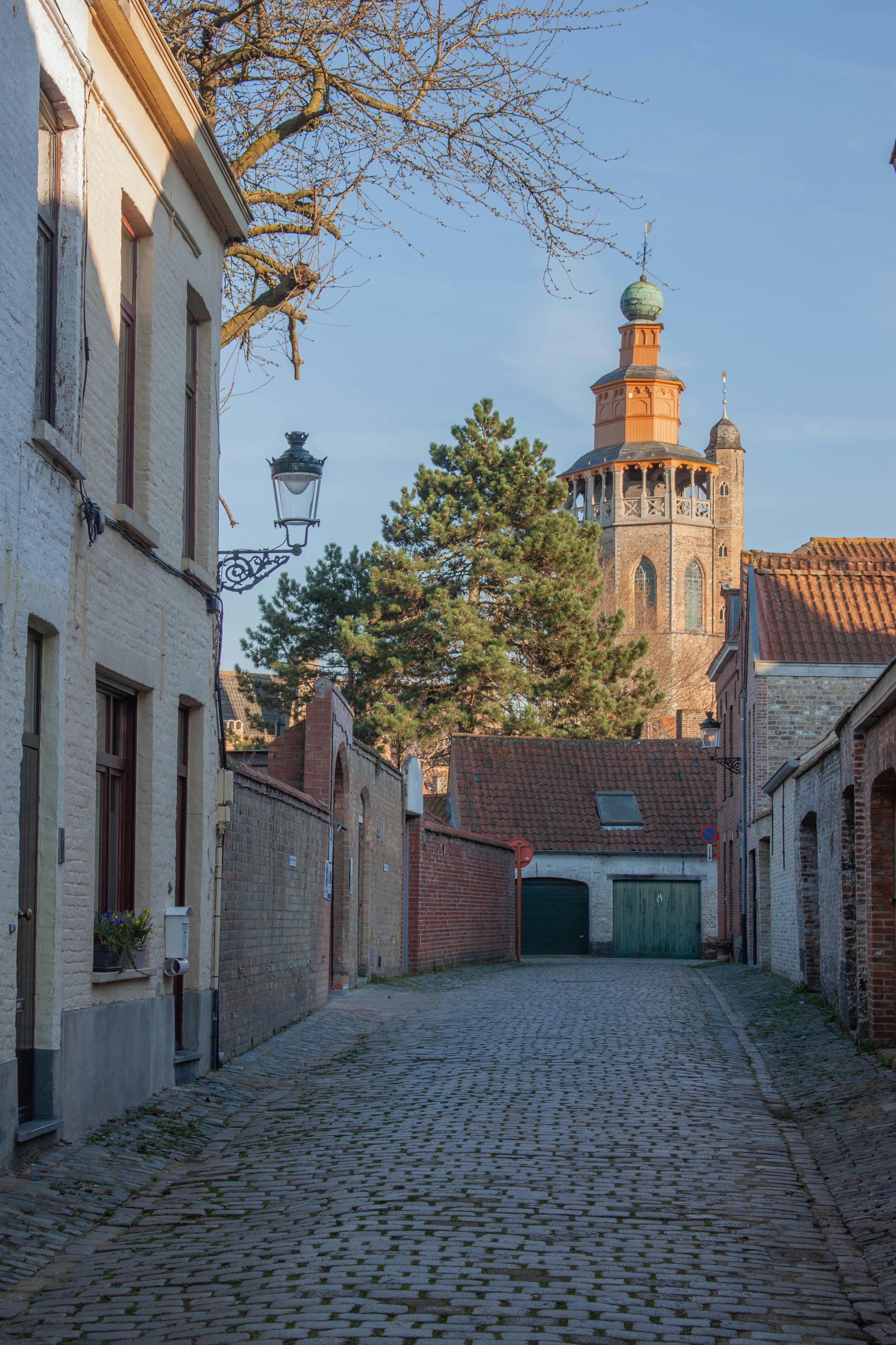 Towering Clocktower Over a Cobblestone Lane