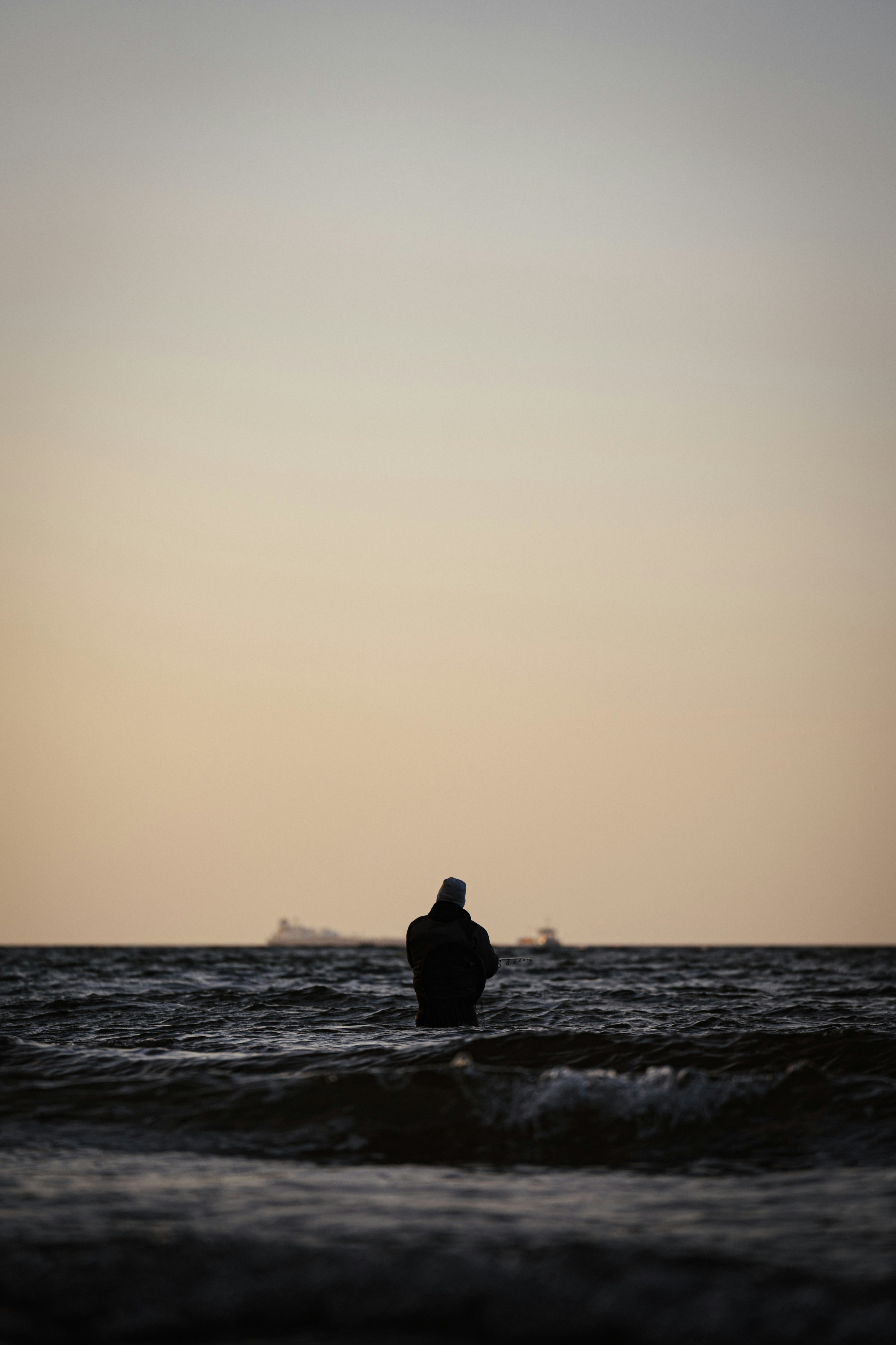 Silhouette at Sea: A solitary figure at dusk grasps the horizon