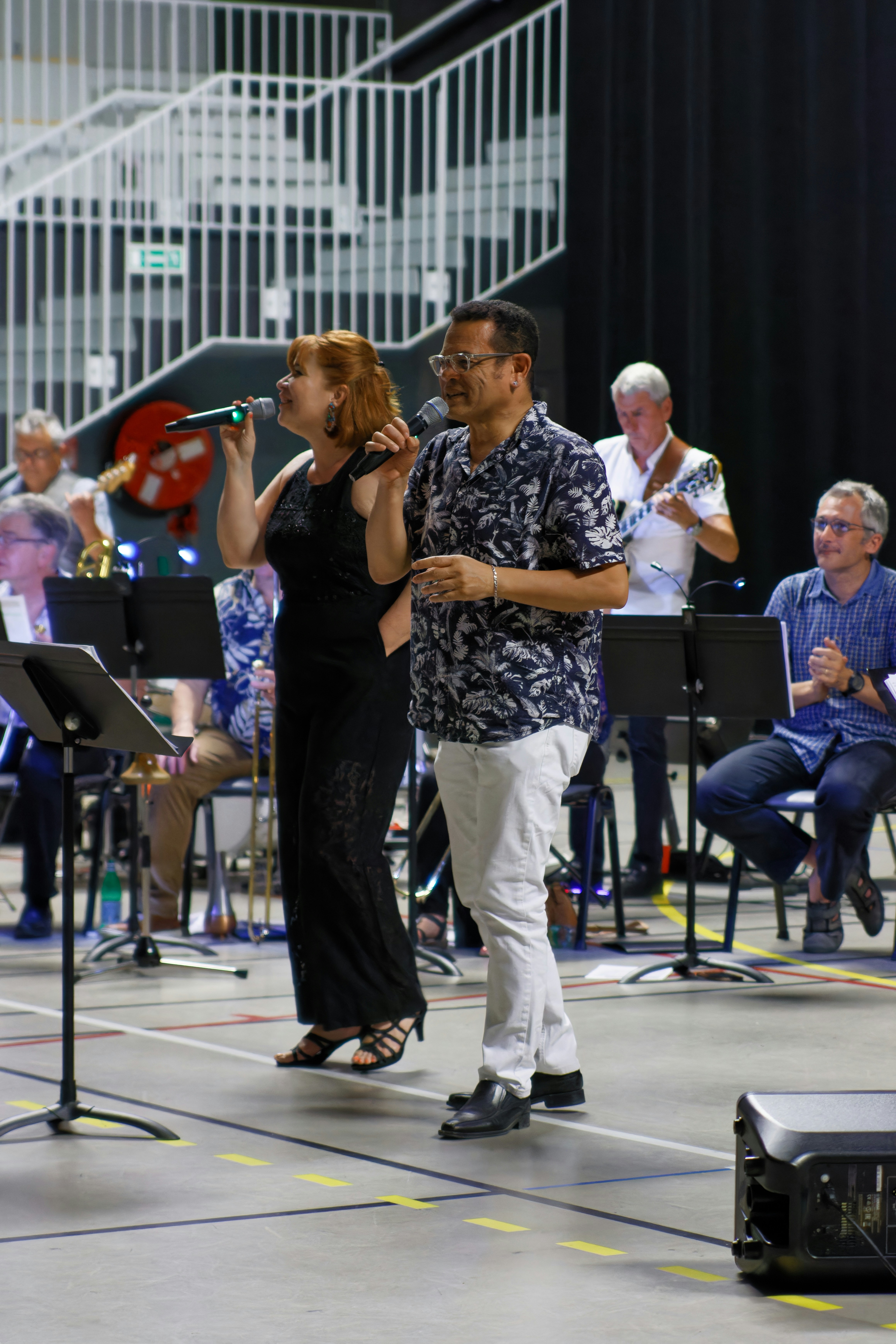 Mid-performance duet: singers front and center with a band behind